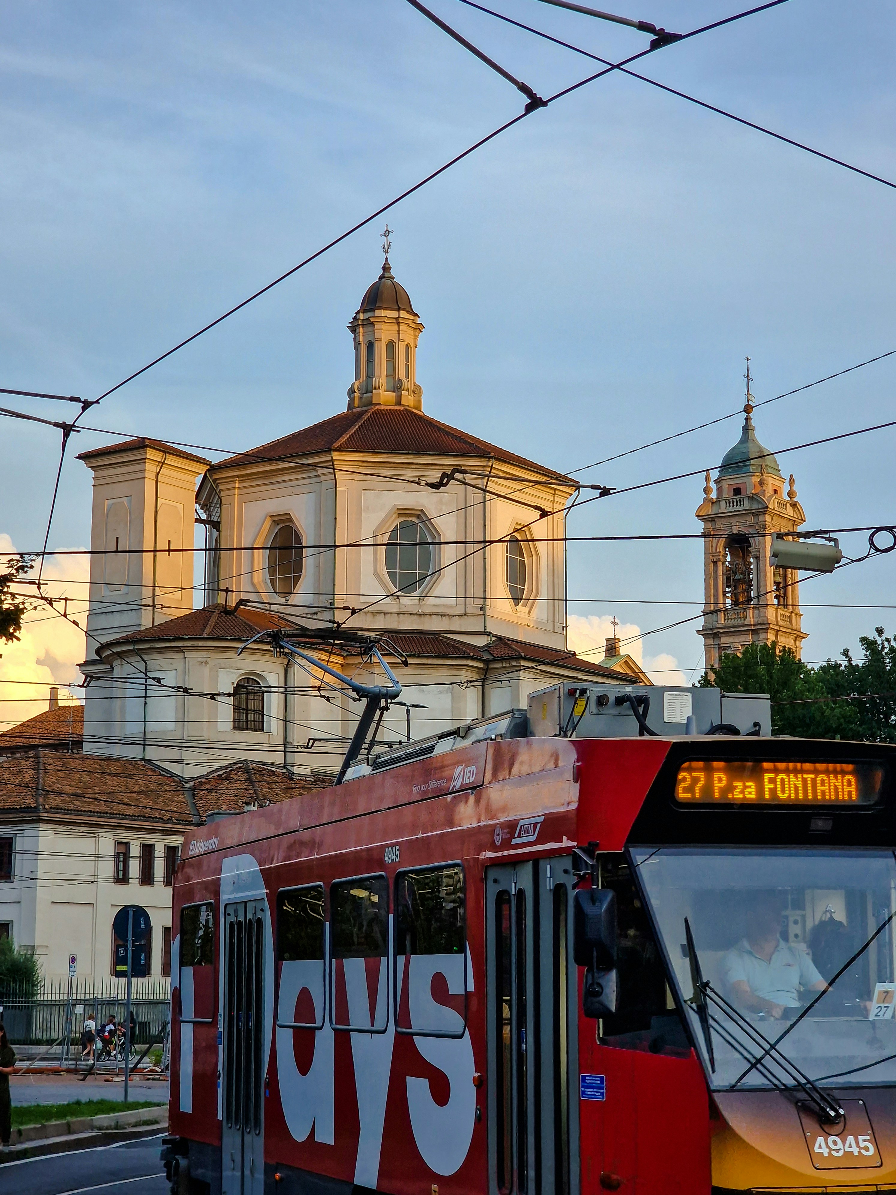 Dome Above the Street: A Sunlit Urban Tapestry with a Red Tram