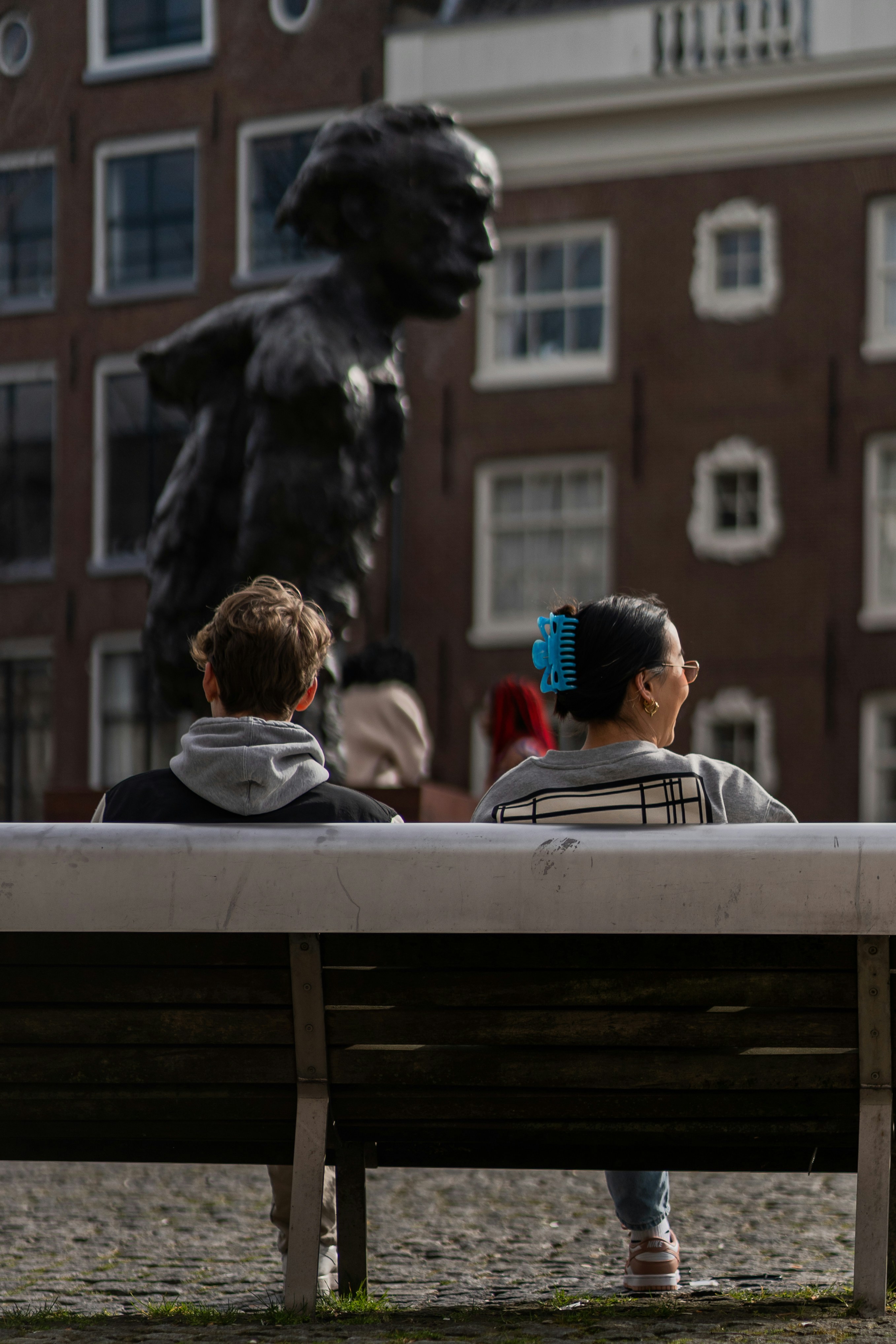 Blue Clip on a City Bench: Quiet Moment Amid Brick Facades