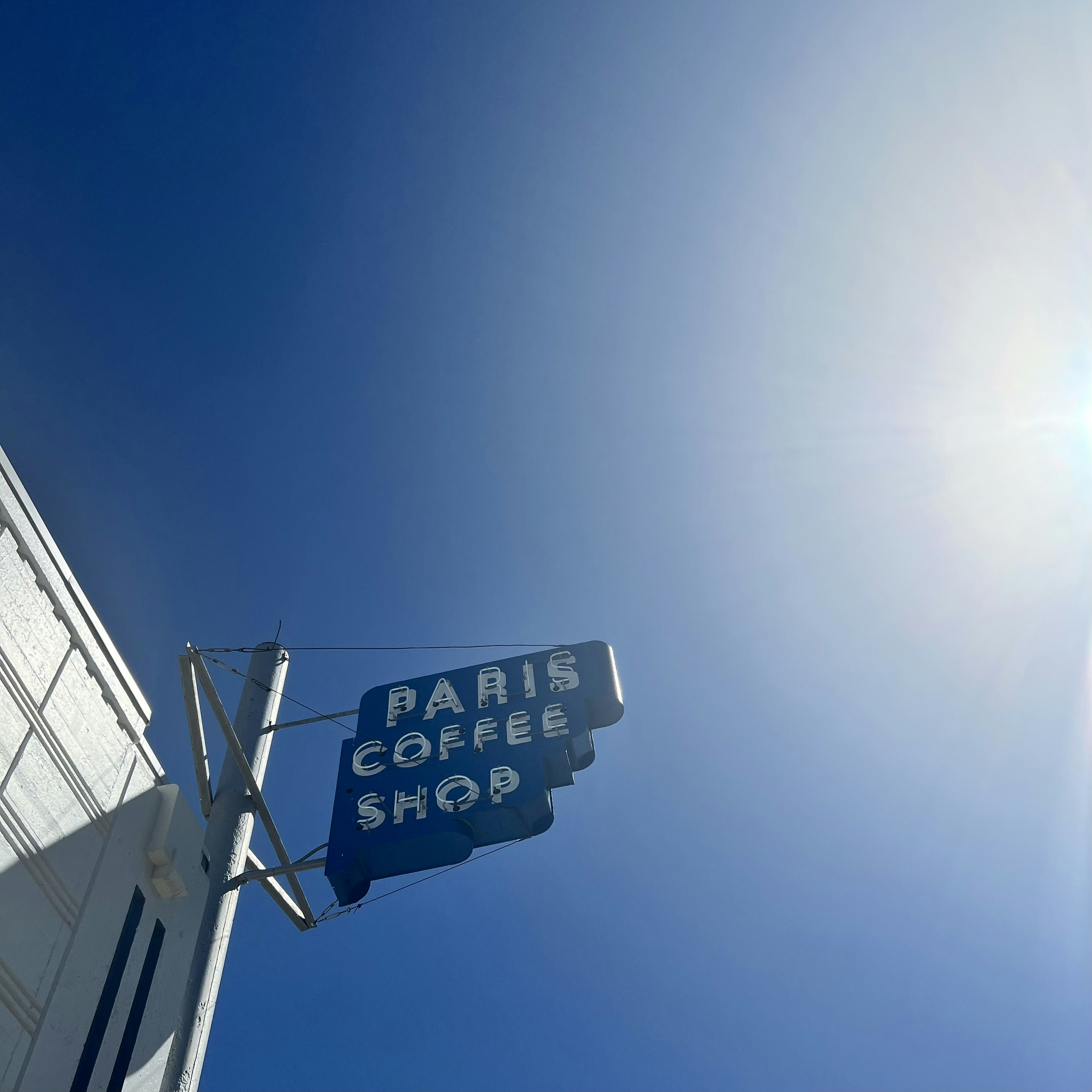 Paris Coffee Shop Sign Bathed in a Brilliant Blue Sky