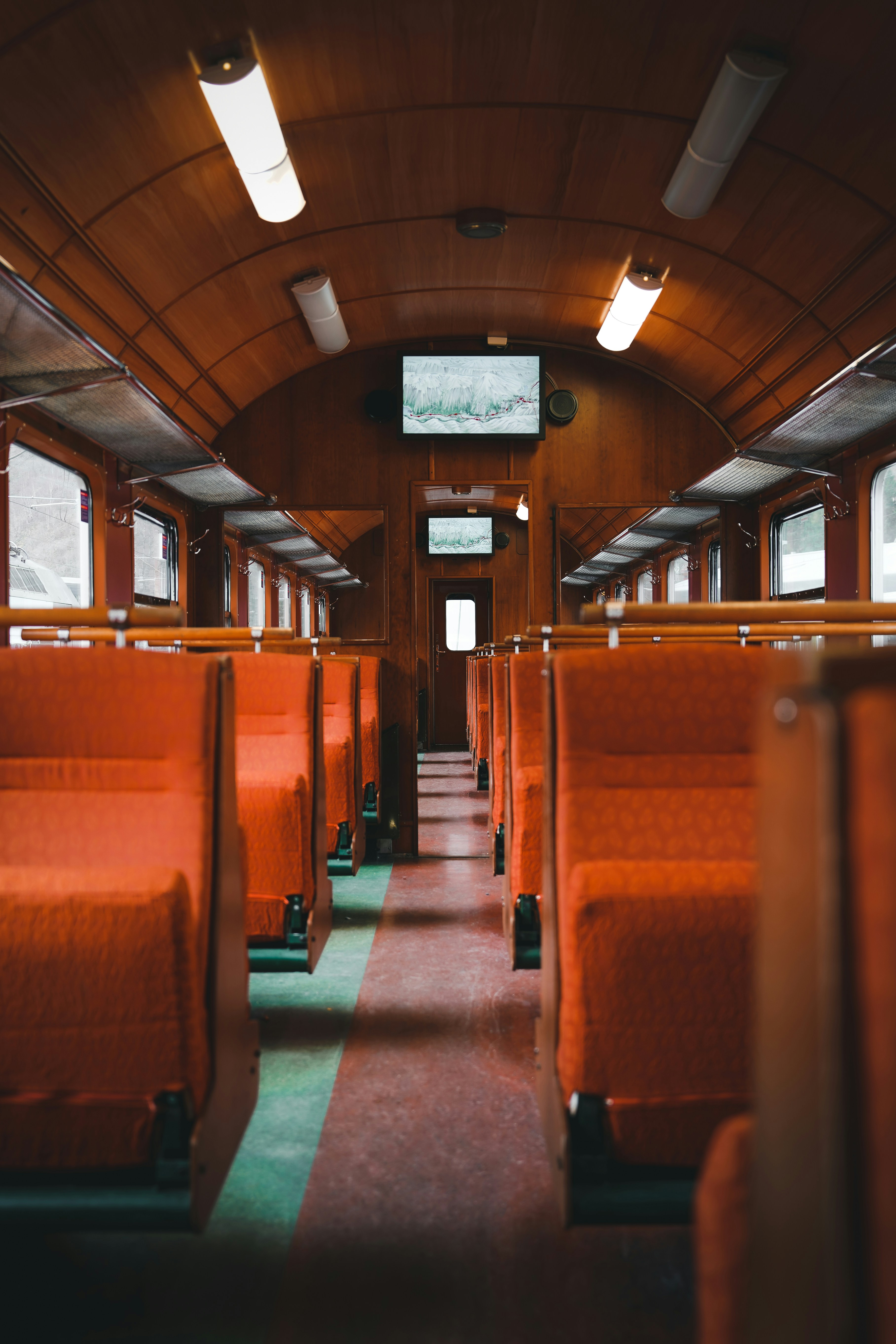 the inside of a train car with orange seats