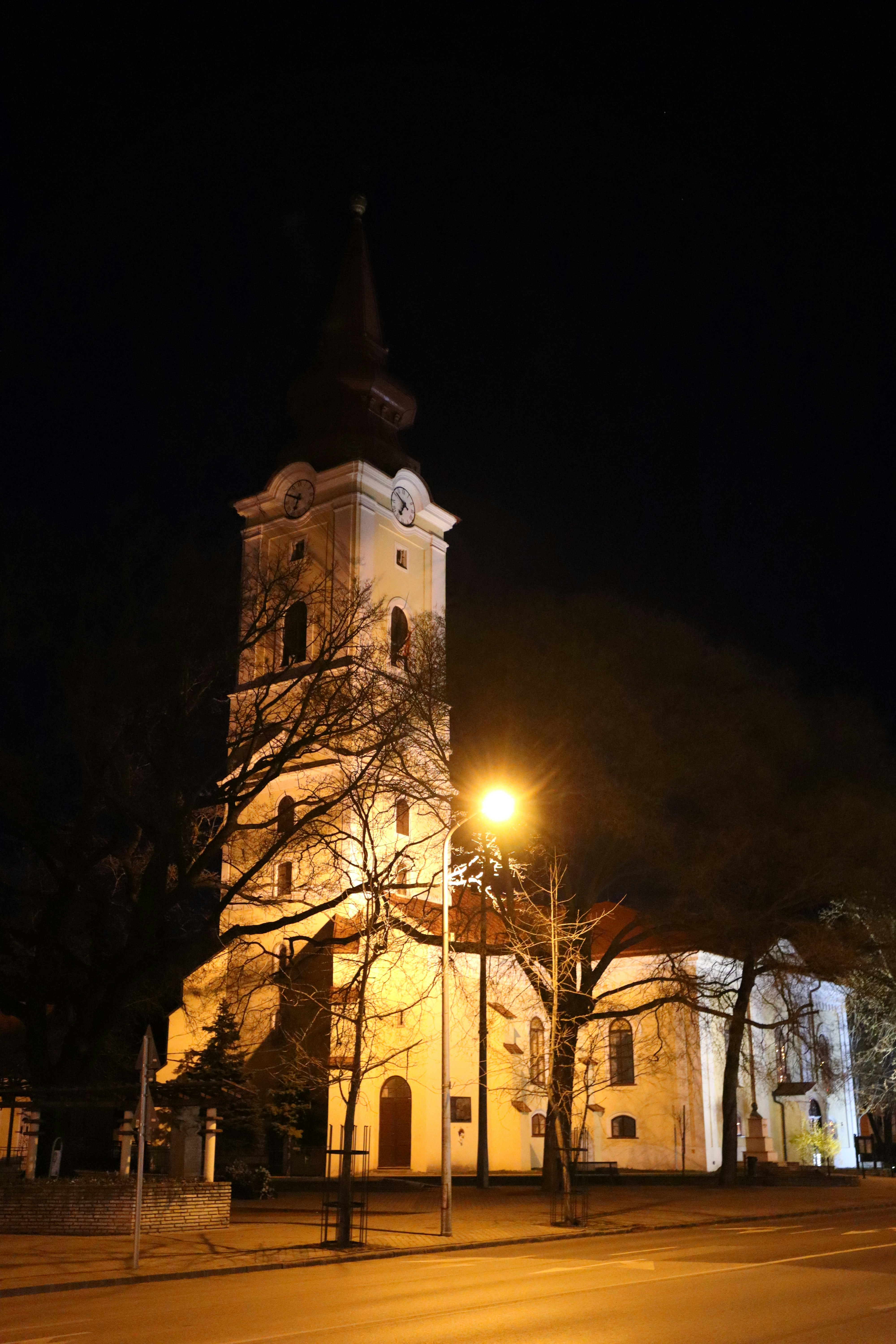 A church lit up at night with a clock tower photo – Free Hungary Image ...