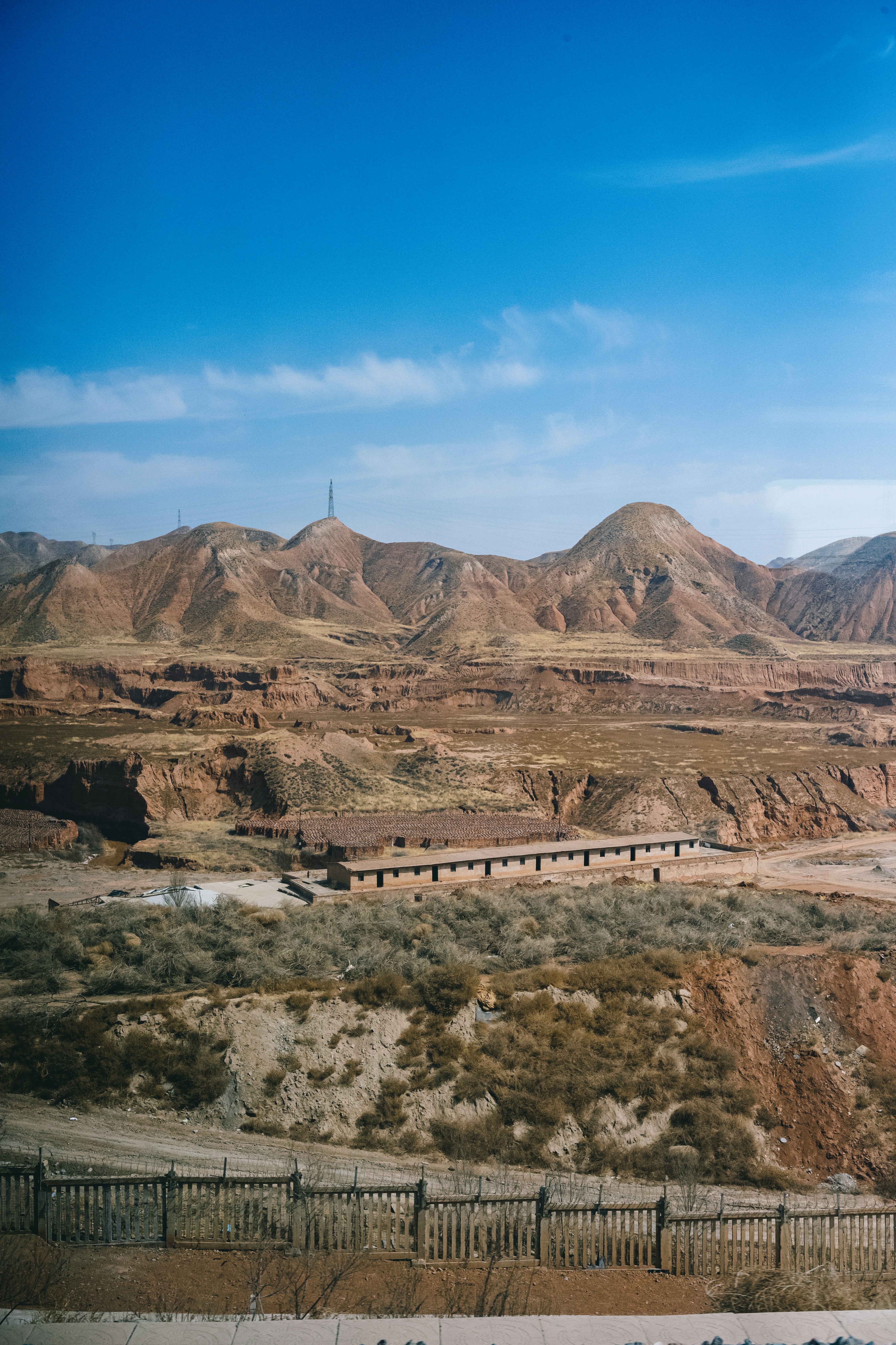 a train traveling through a desert landscape with mountains in the background