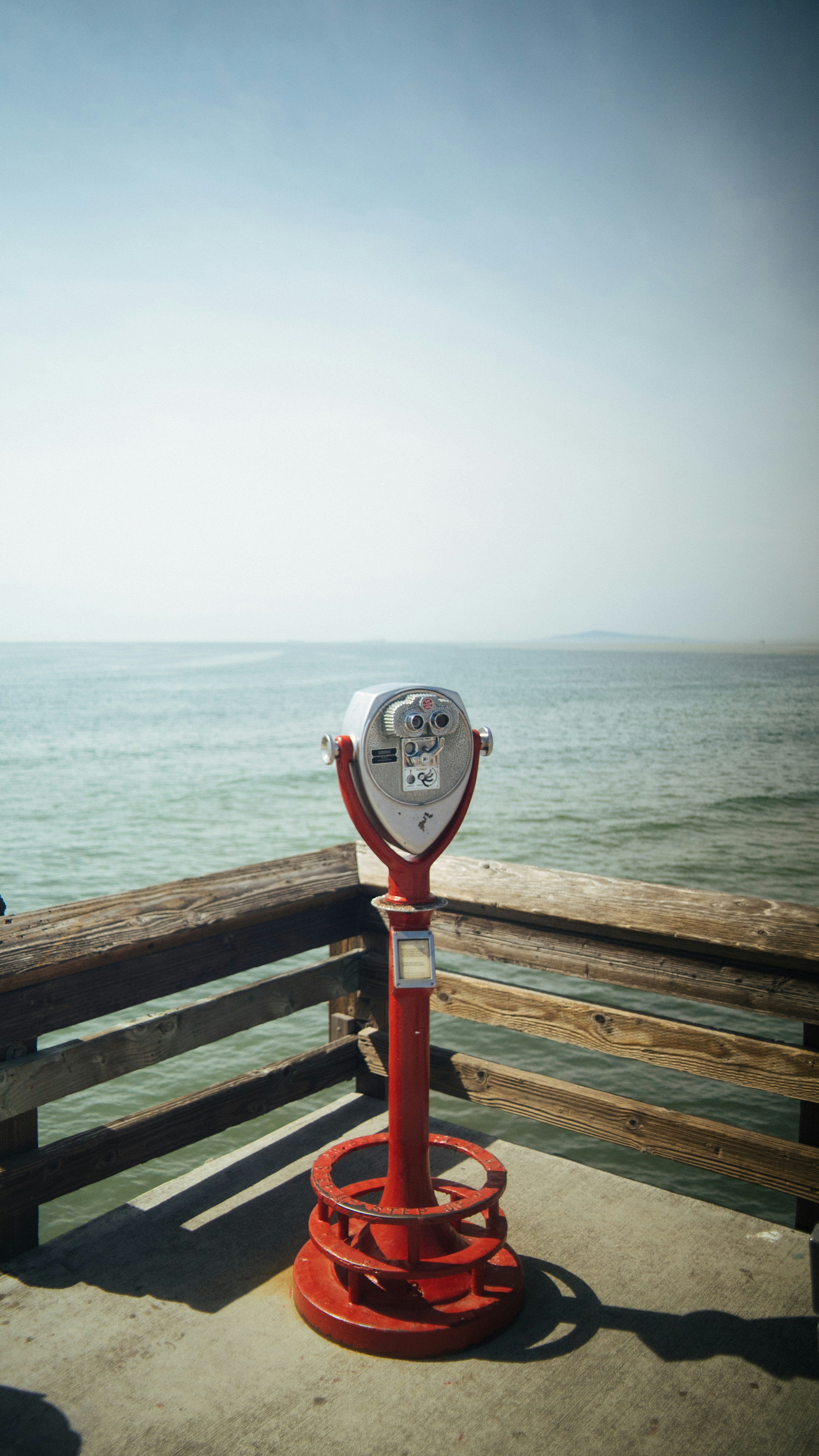 Red Seaside Telescope Anchors a Tranquil Pier View