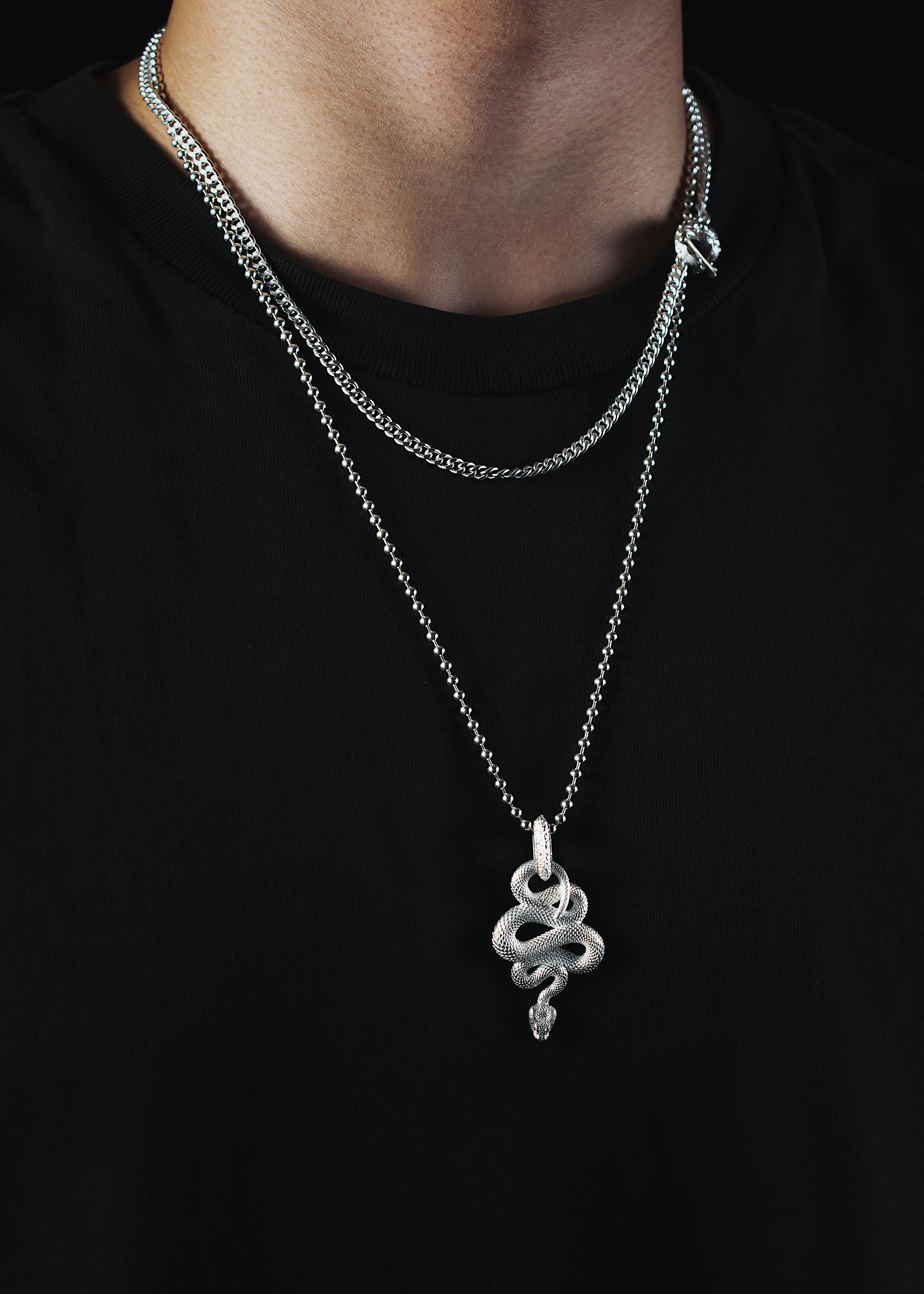 Un homme portant un collier avec un serpent dessus photo – Image ...