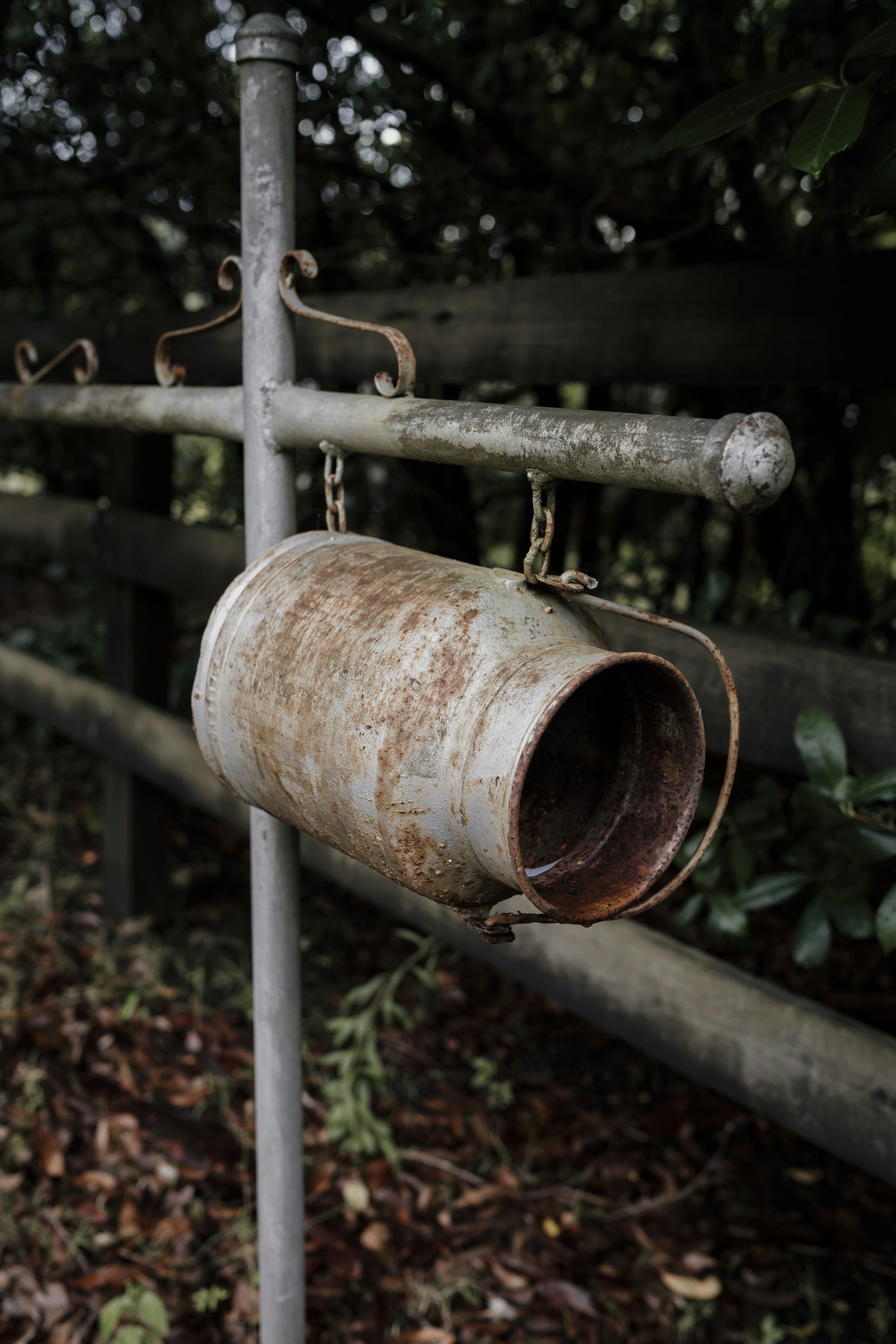 A rusted metal pole with a rusted can hanging from it photo – Free ...