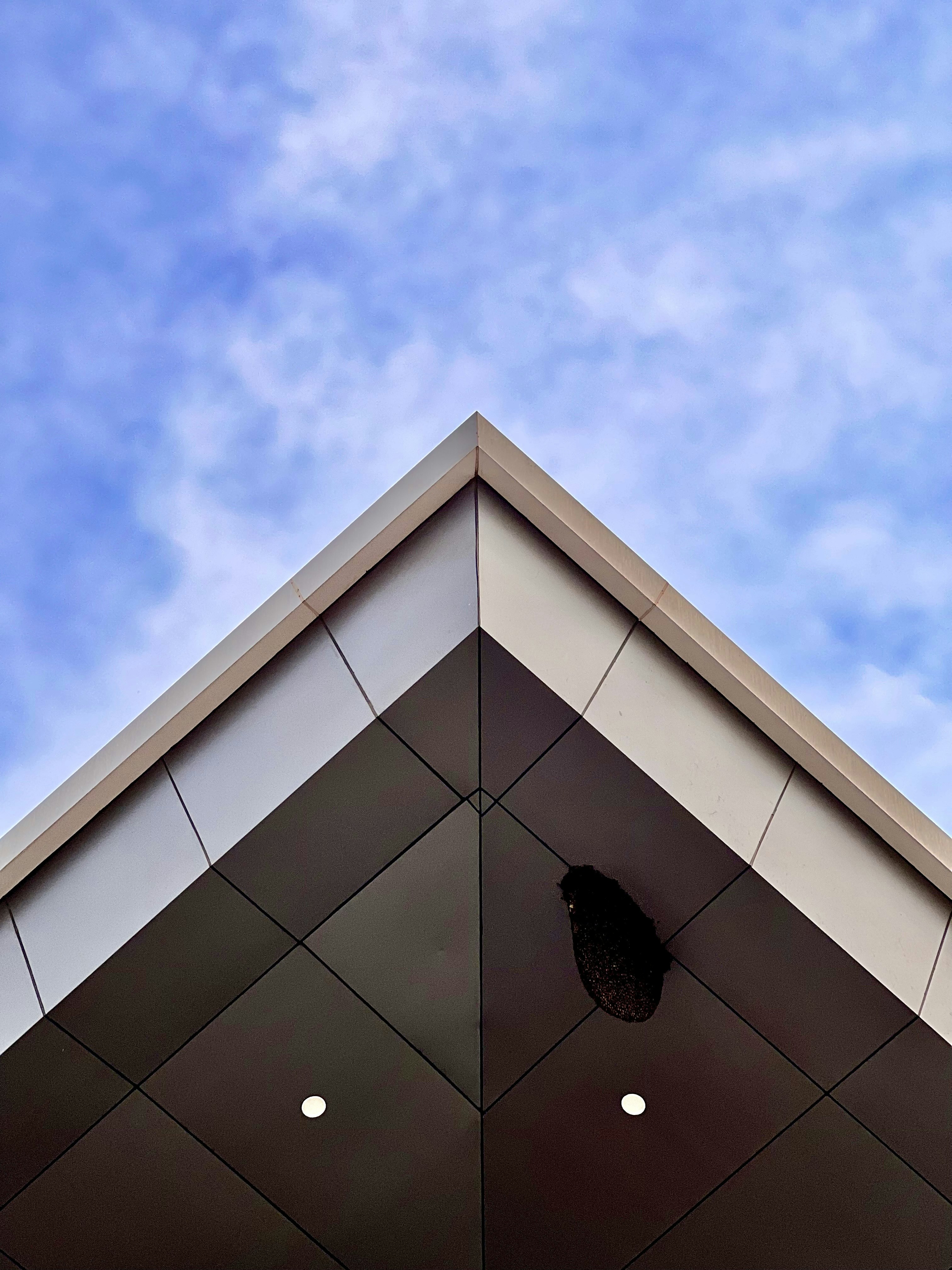 a clock on the side of a building with a sky background