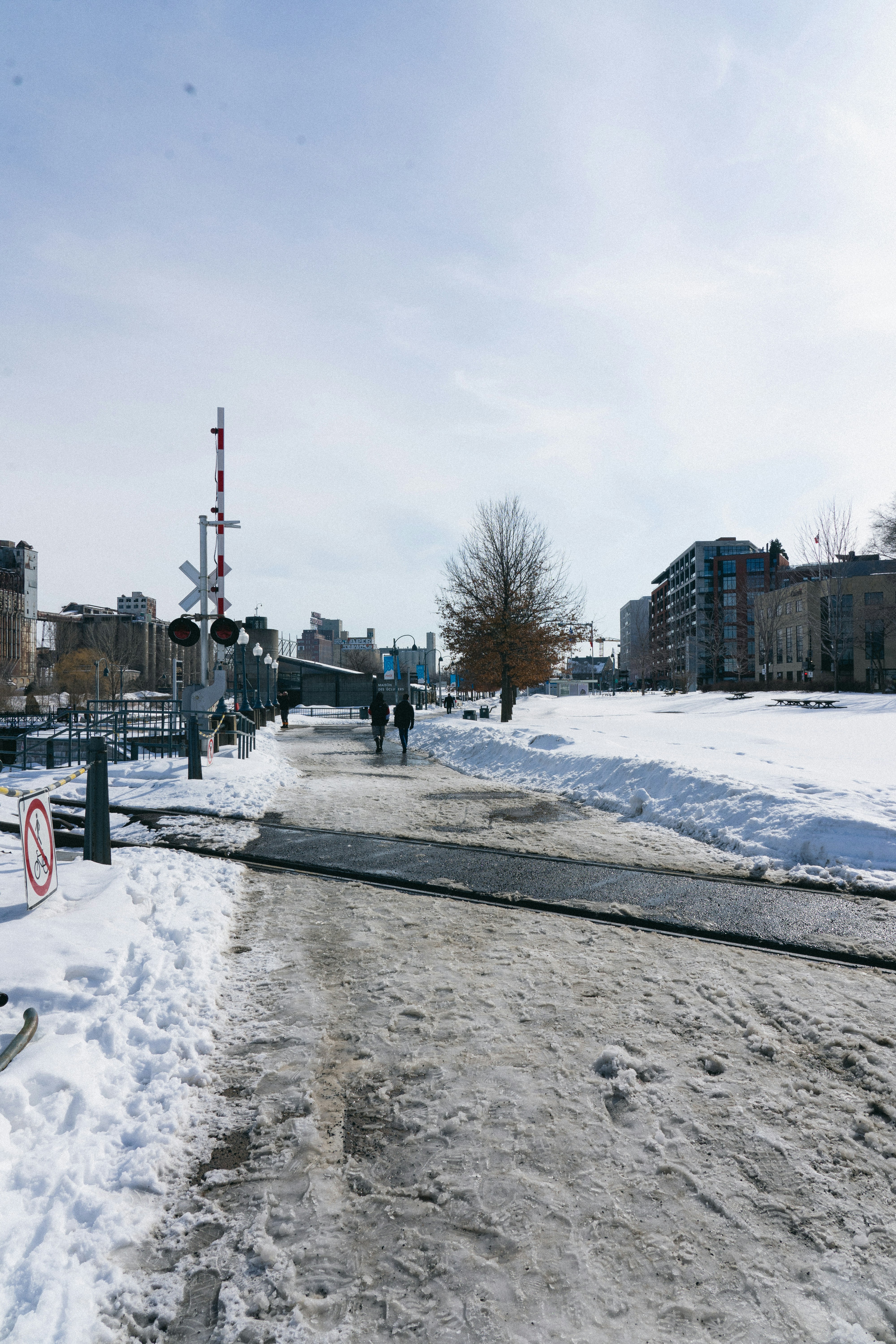 a snow covered street with people walking on it
