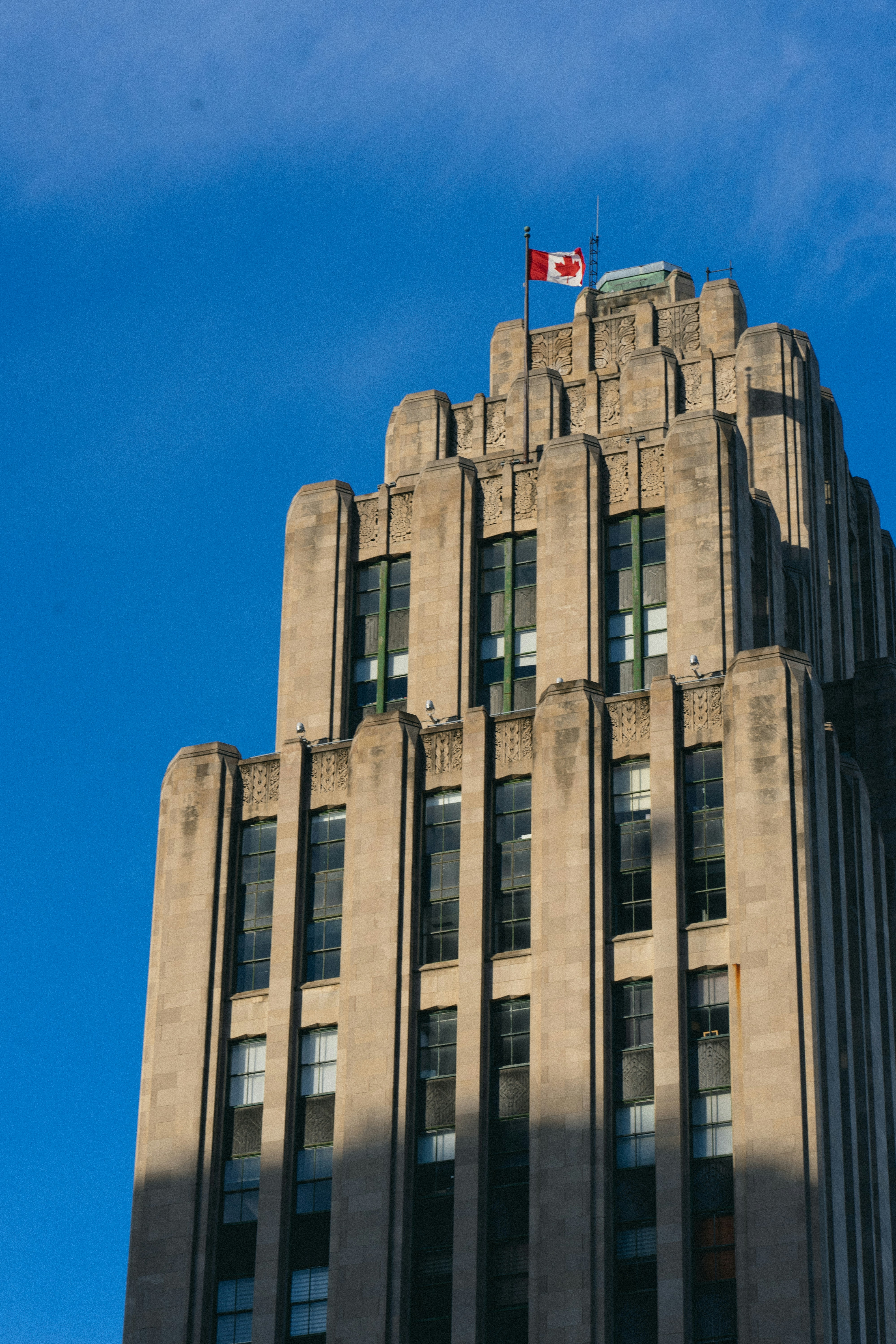 Flag atop the Art Deco tower under a clear blue sky