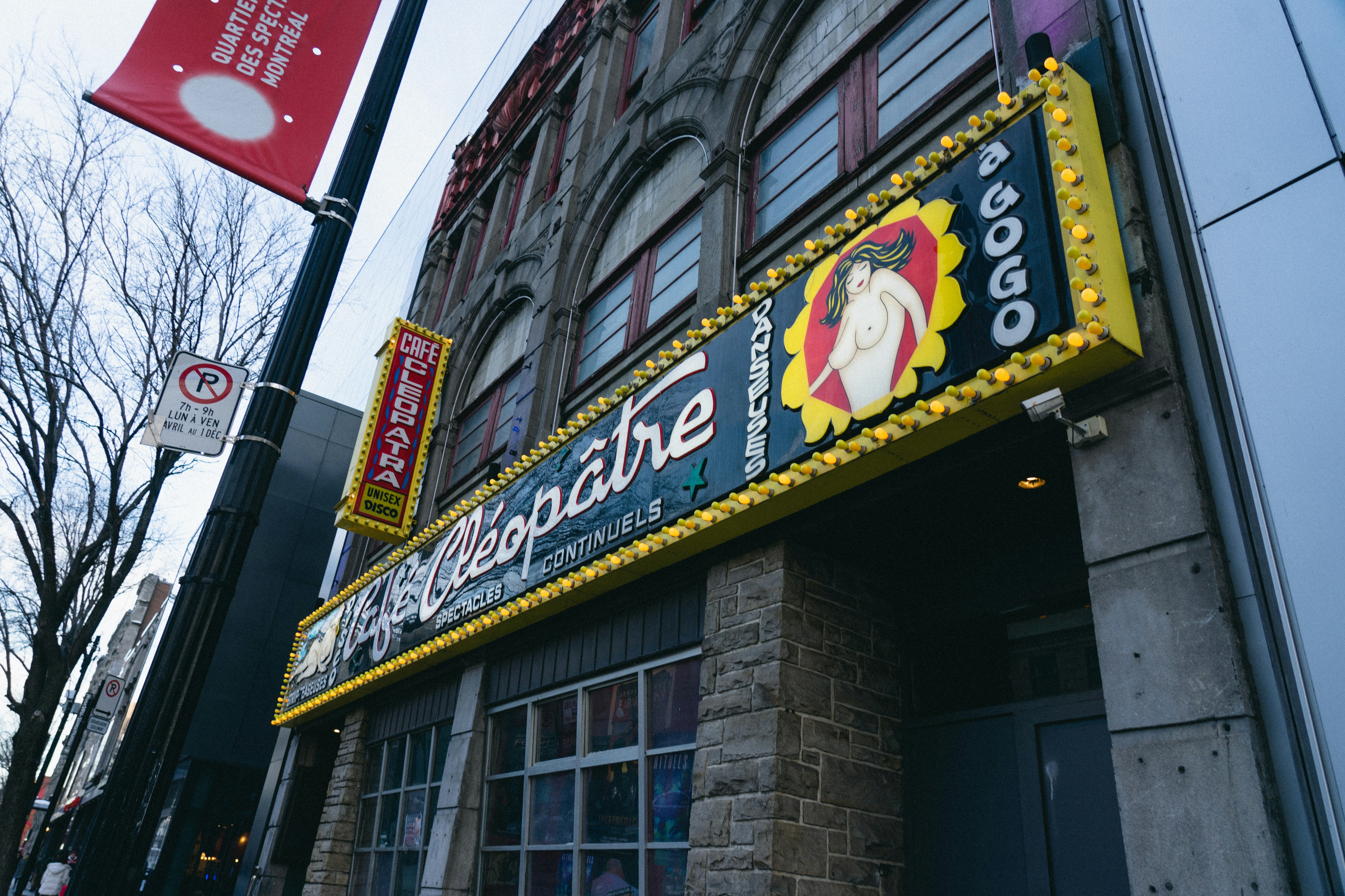 Vibrant theater marquee showcasing the name 'Cleopatre' with a whimsical illustration, set against a historic building facade.