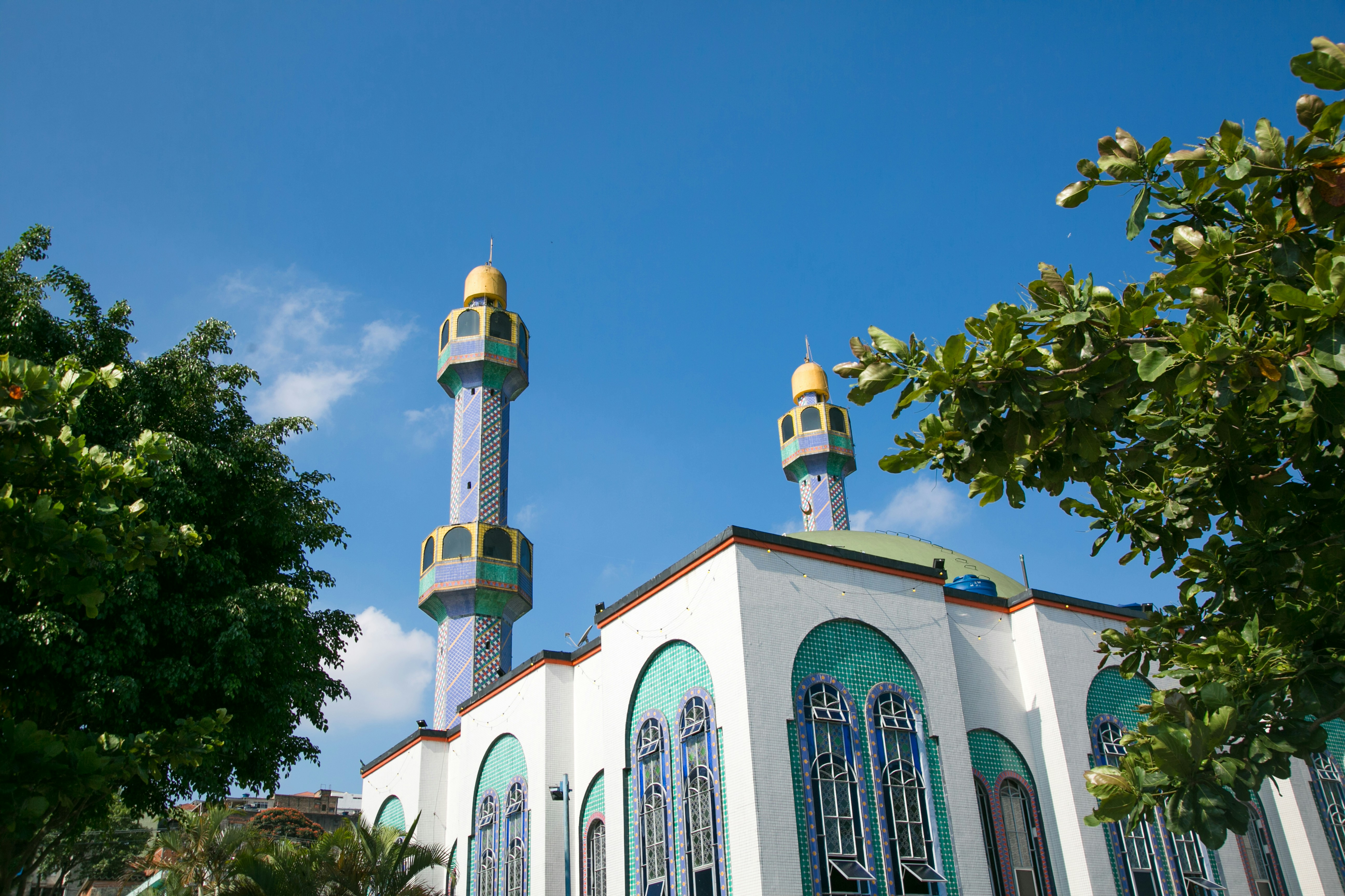 A large white building with two blue and yellow towers photo – Free ...