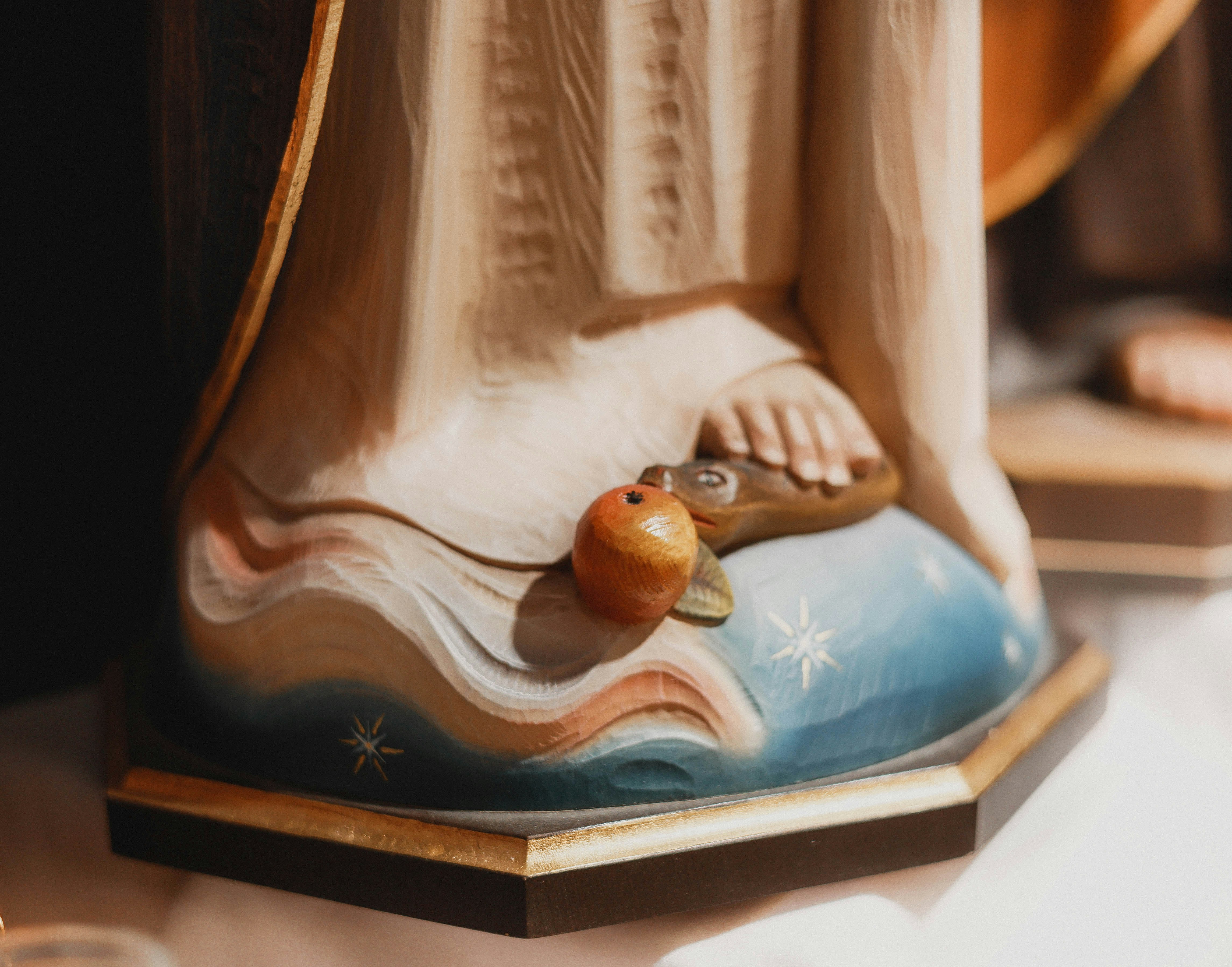 Orange at the Foot of a Painted Saint: Warm Light on a Tiny Shrine