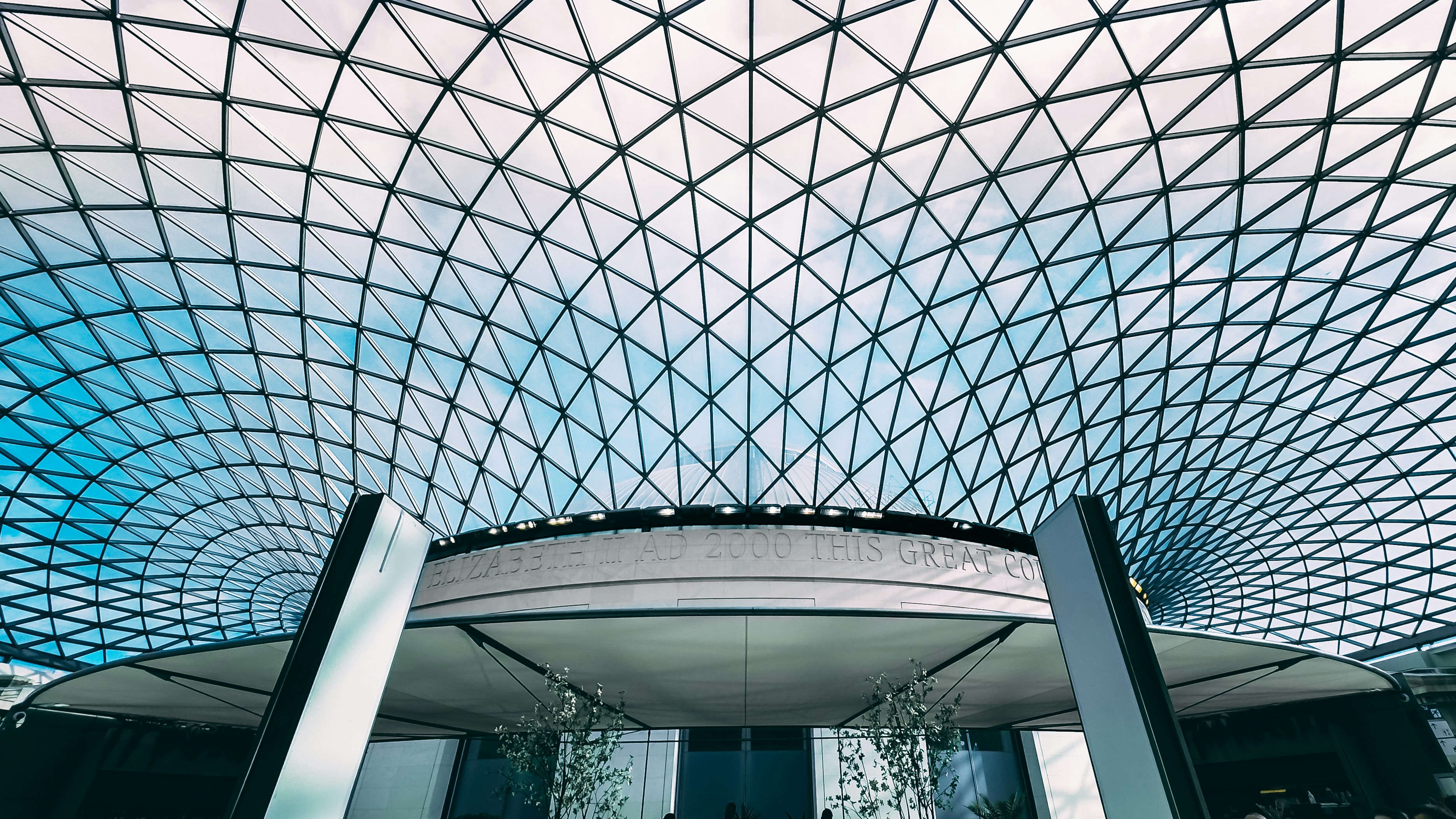 A building with a glass roof and people walking around photo – Free ...