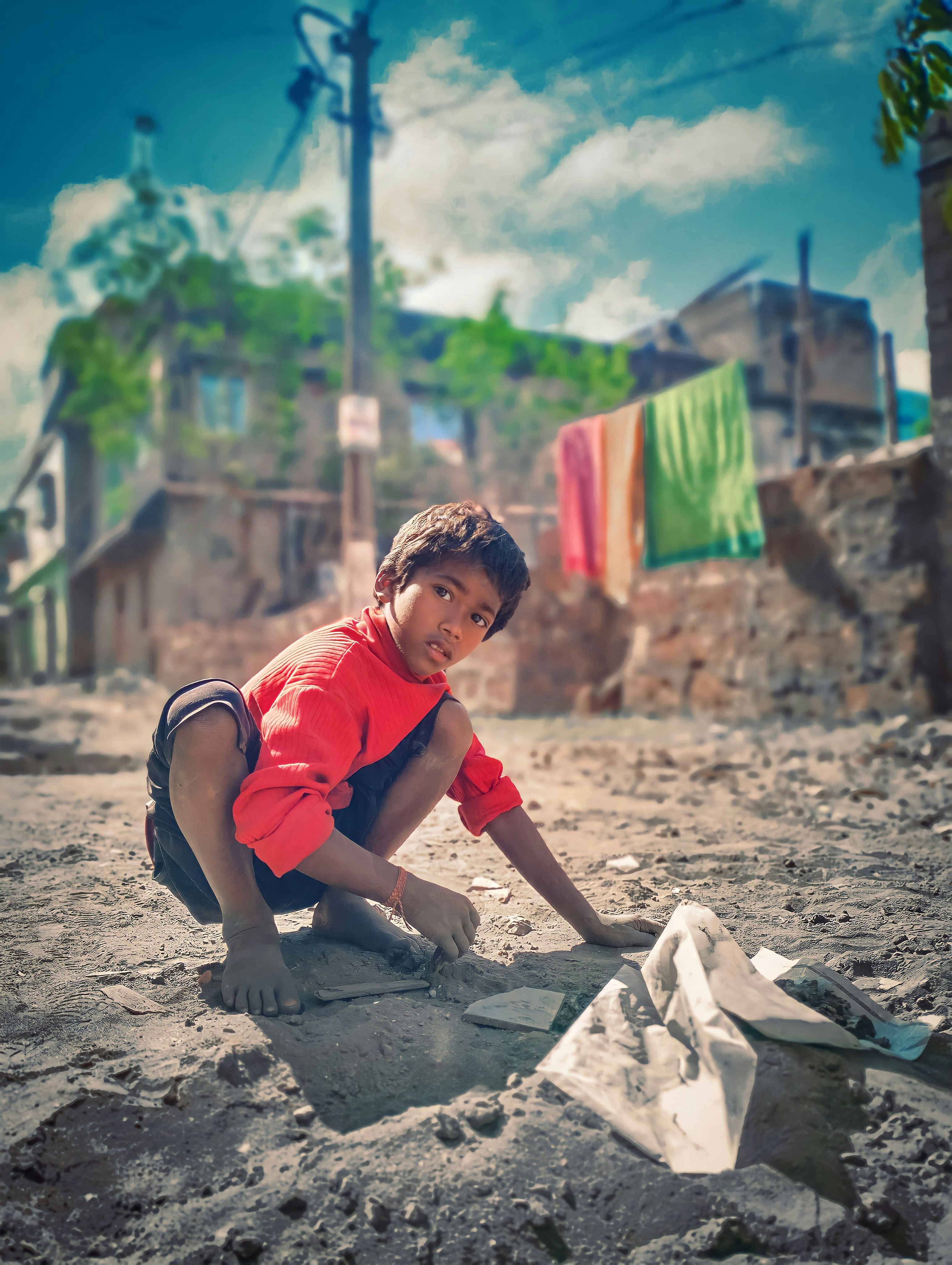 A young boy is playing in the dirt photo – Free Boy sad Image on Unsplash