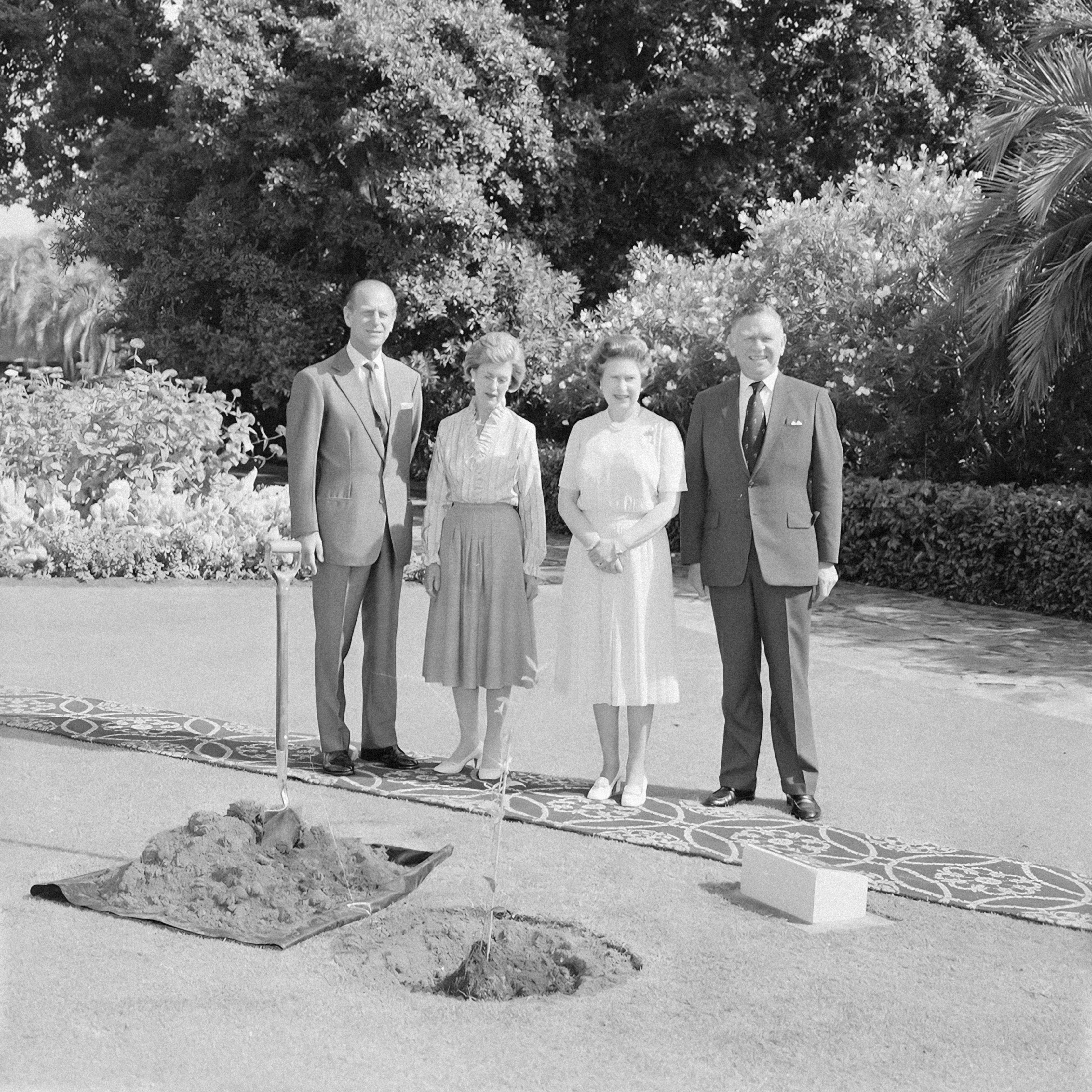 Monochrome Garden Edge Portrait: Four Attendees in Formal Attire