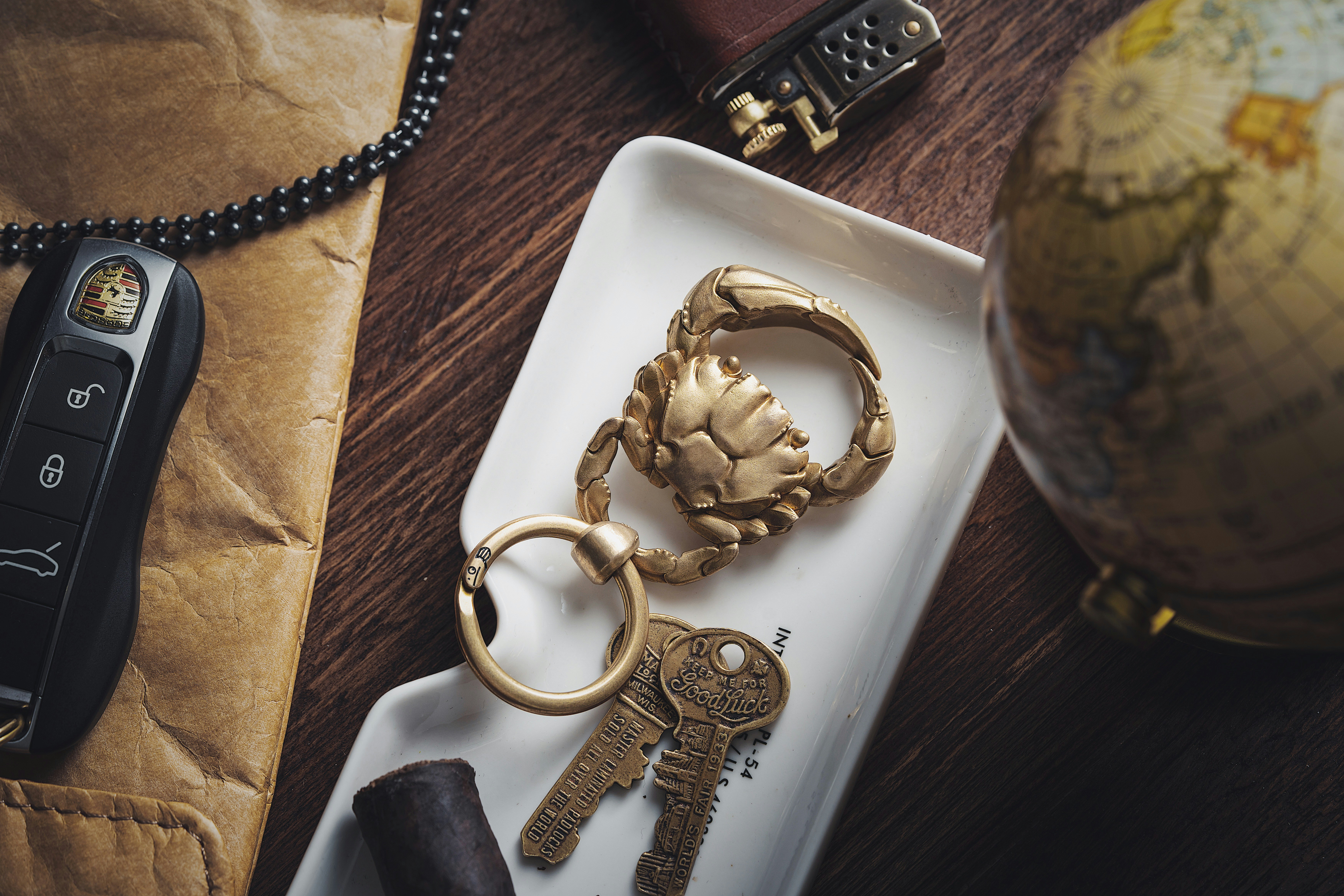 Desk Essentials: Keys, Ring, and Globe on a Wooden Workspace