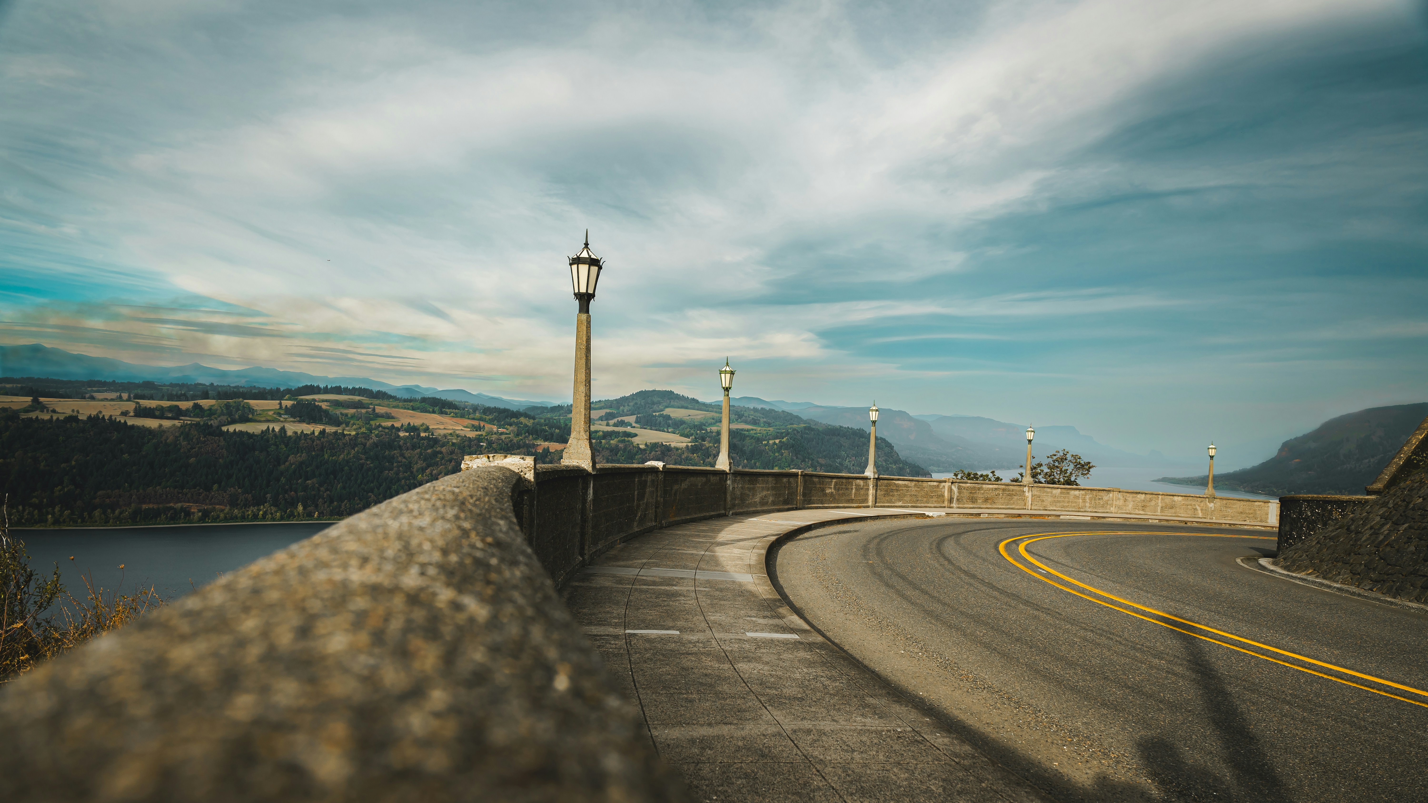 Lamp-Lit Bend: A Quiet Bridge Curves Toward the Distant Ridge