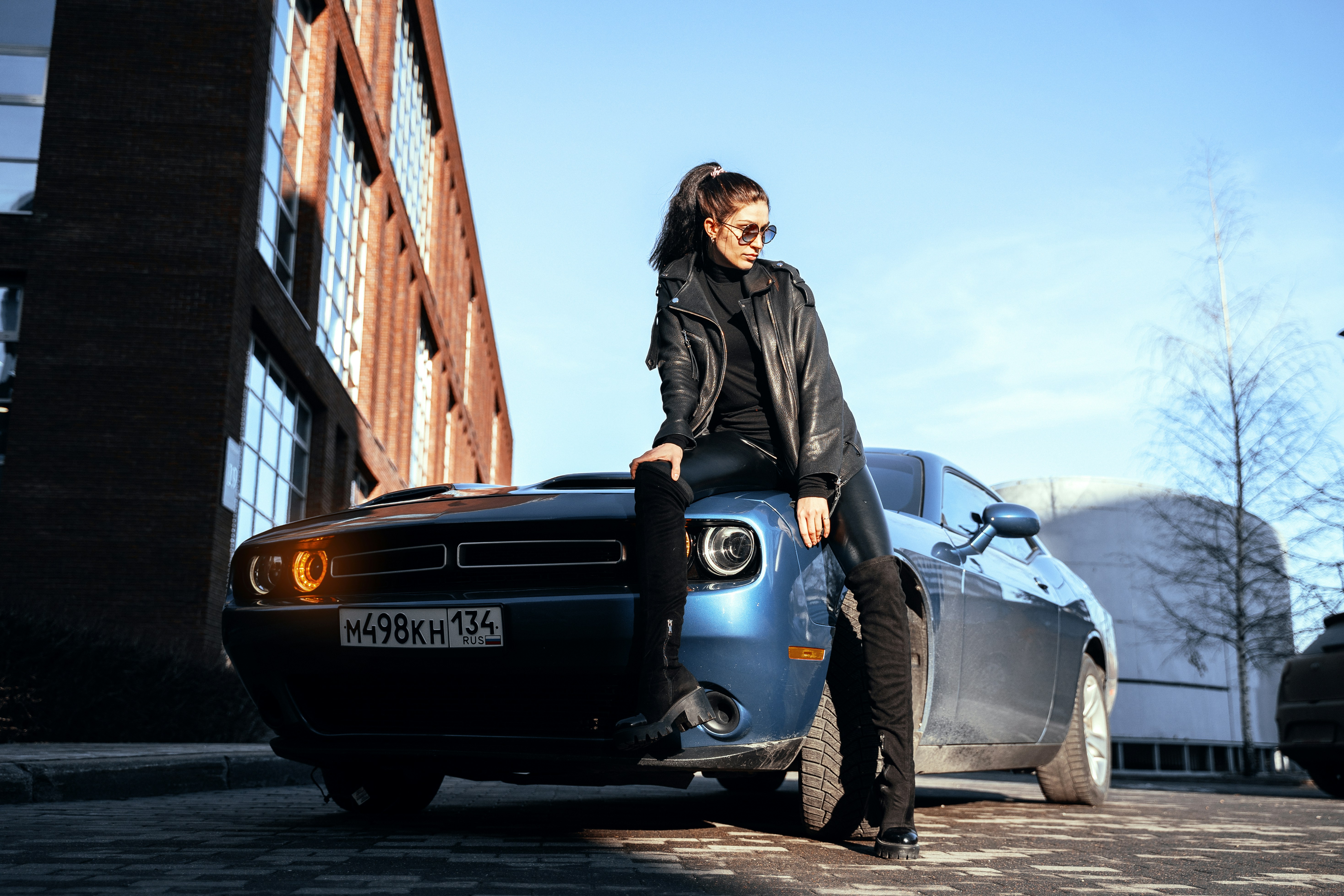 Eine Frau, die sich auf die Motorhaube eines Autos stützt Foto ...