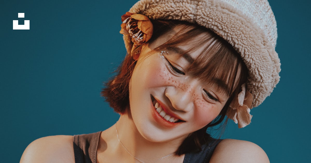 머리에 모자를 쓰고 땅에 앉아 있는 여자 사진 Unsplash의 무료 미소 이미지