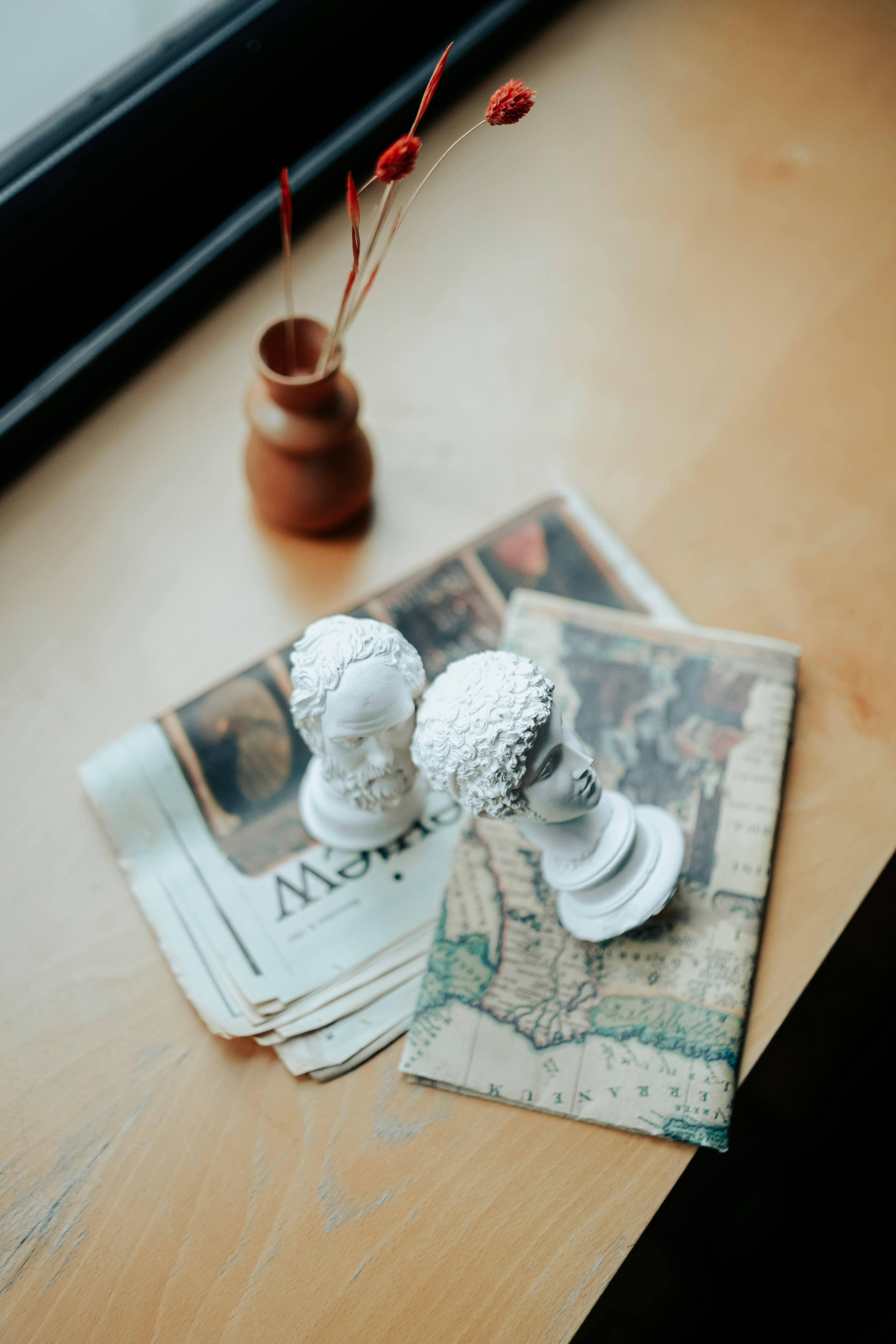 Miniature Busts Resting on a Timeworn Map