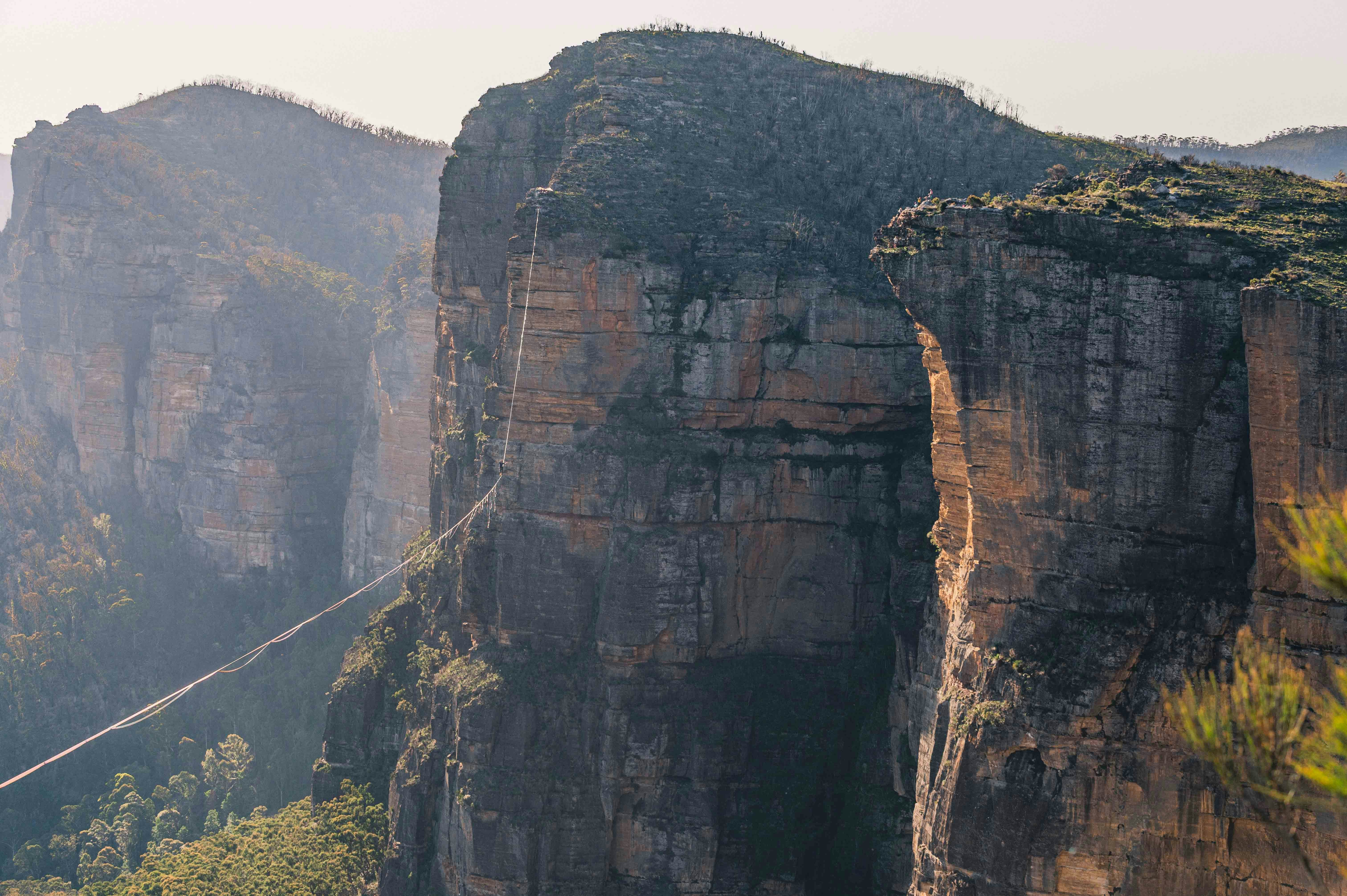 A rope bridge suspended between two rocky mountains photo – Free ...