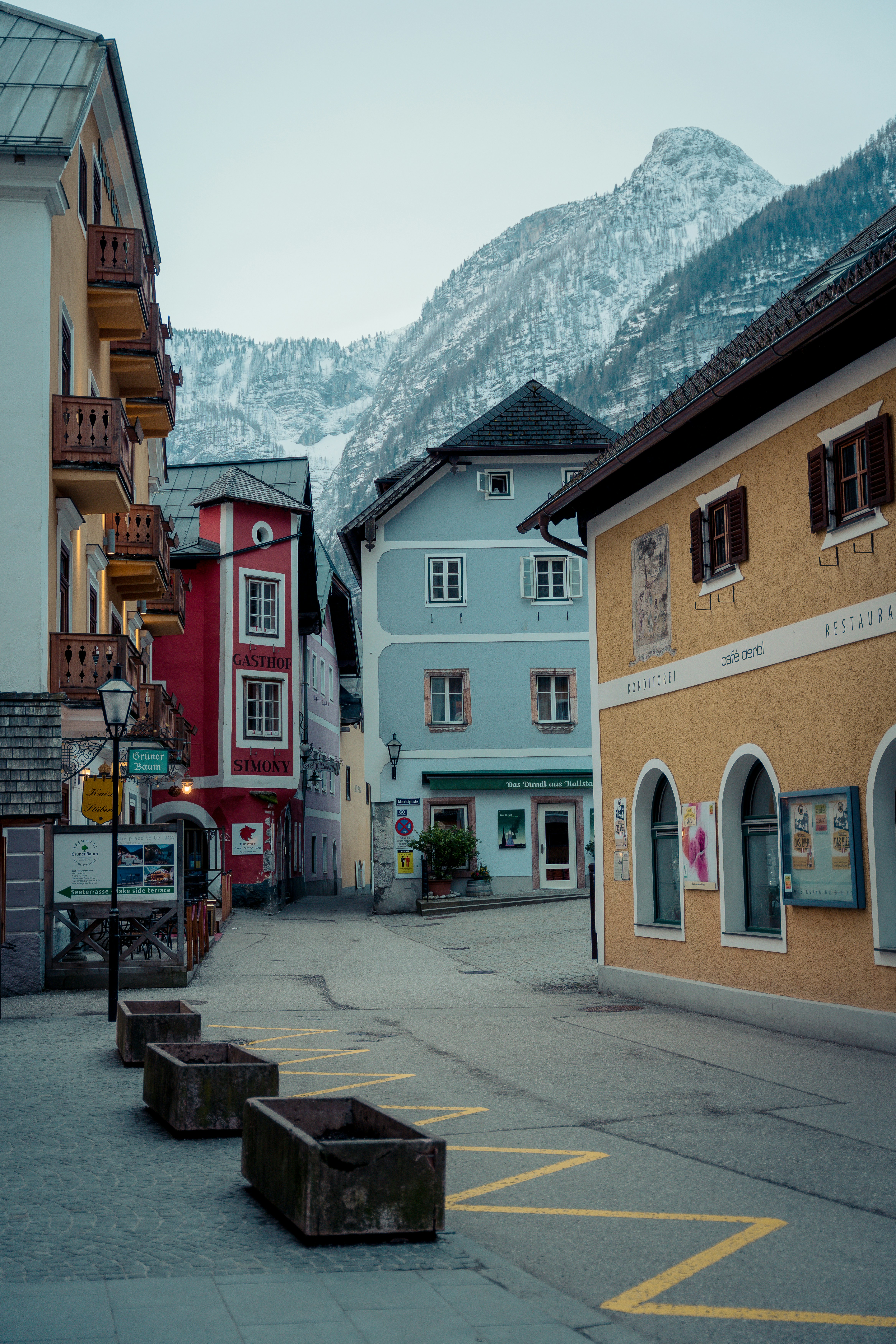Pastel Alpine Lane: Street Framing Snowy Peaks