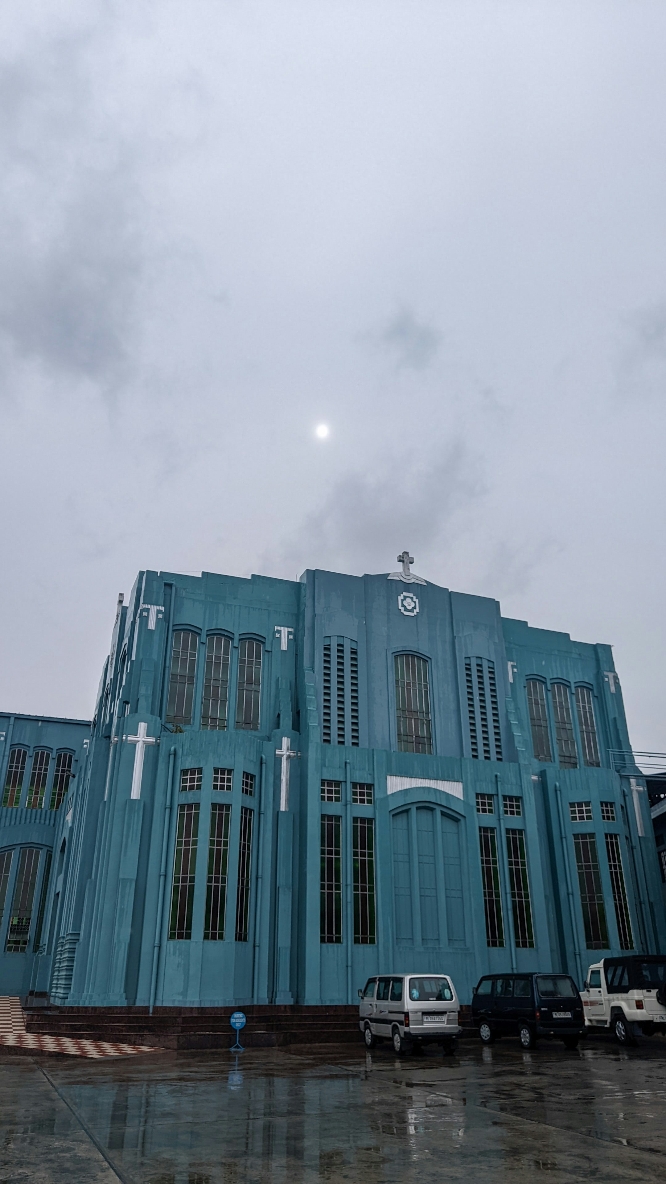 Un grand bâtiment bleu avec des voitures garées devant photo – Photo ...