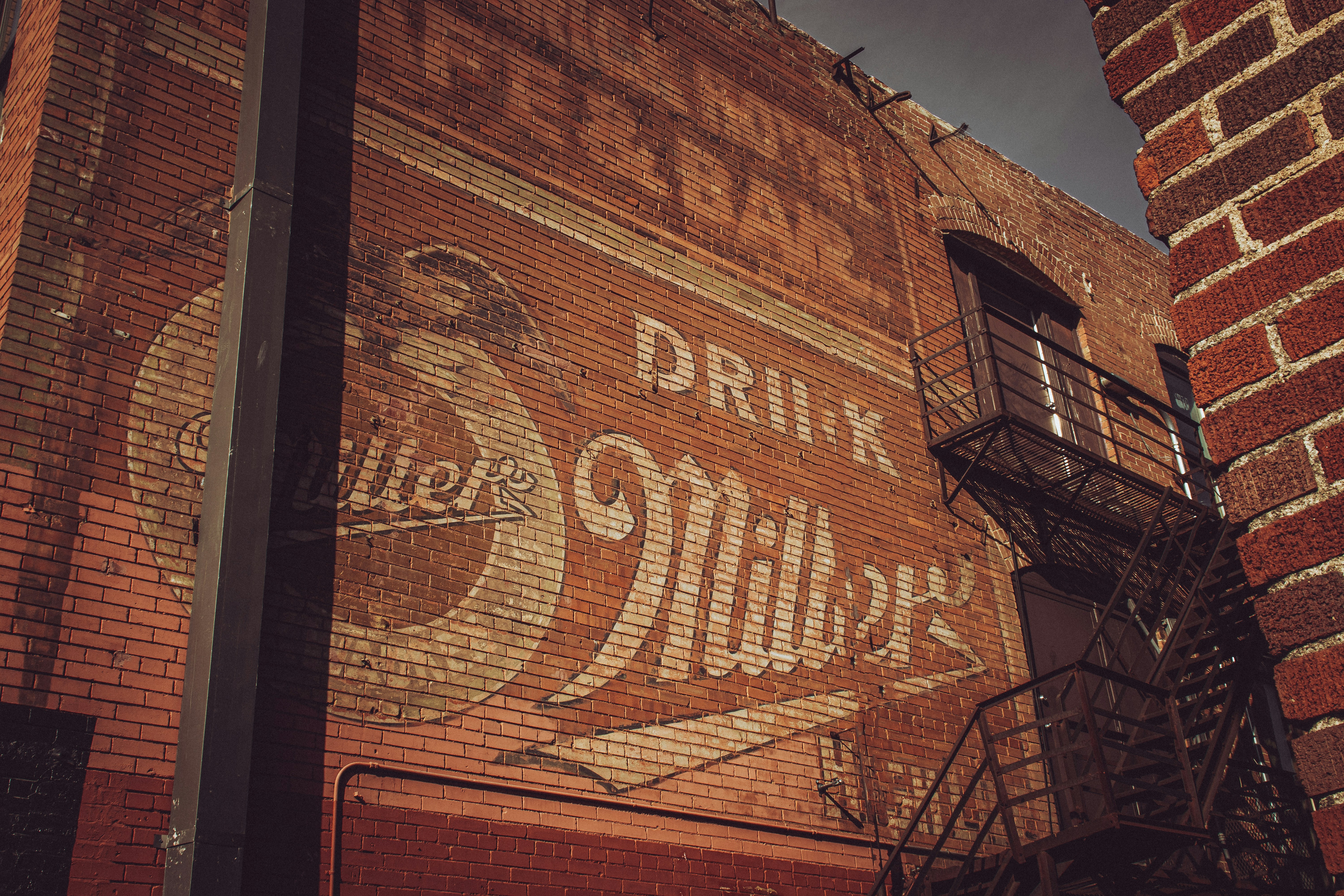 a brick building with a coca cola advertisement painted on it
