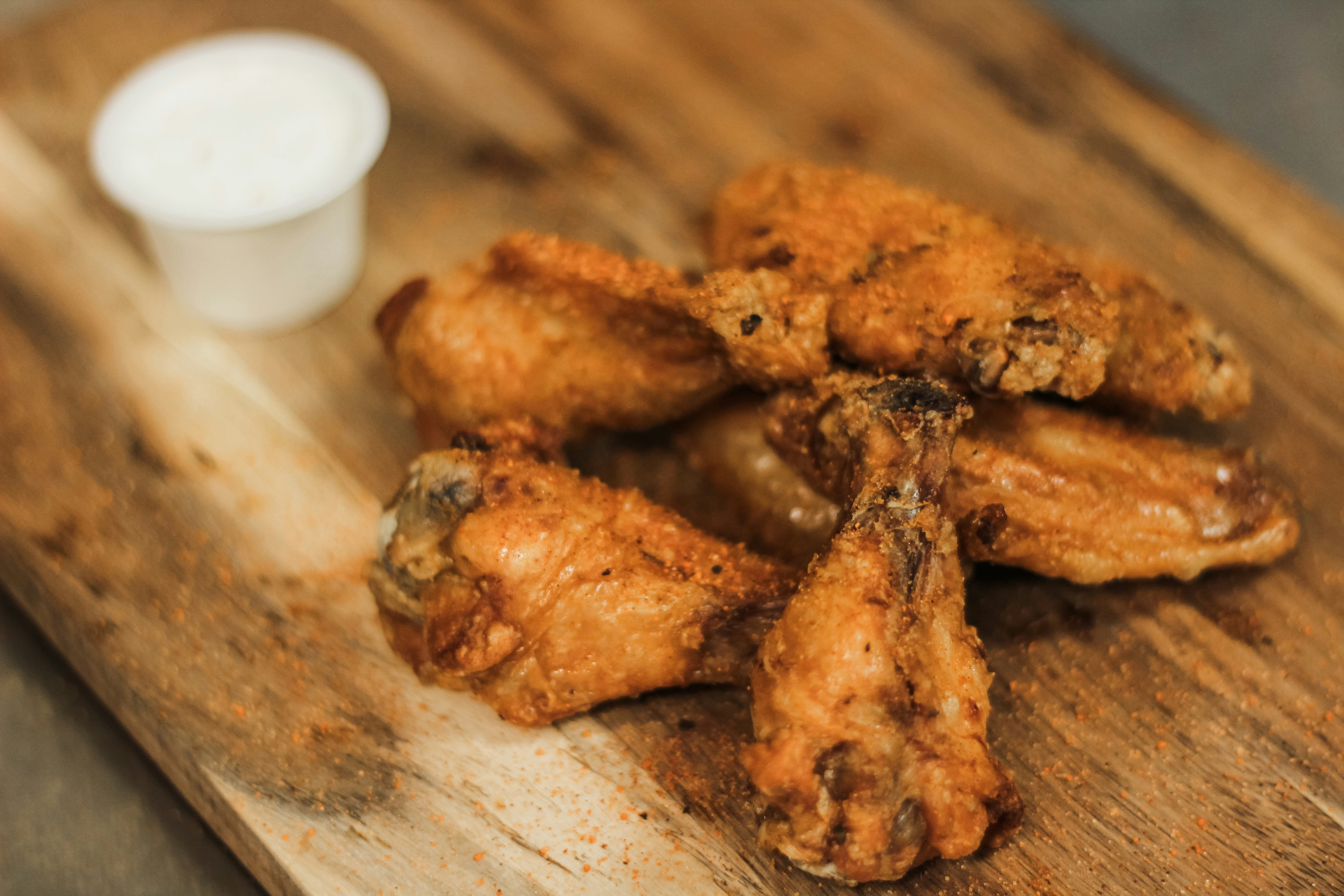 A wooden cutting board topped with fried chicken wings photo – Free ...