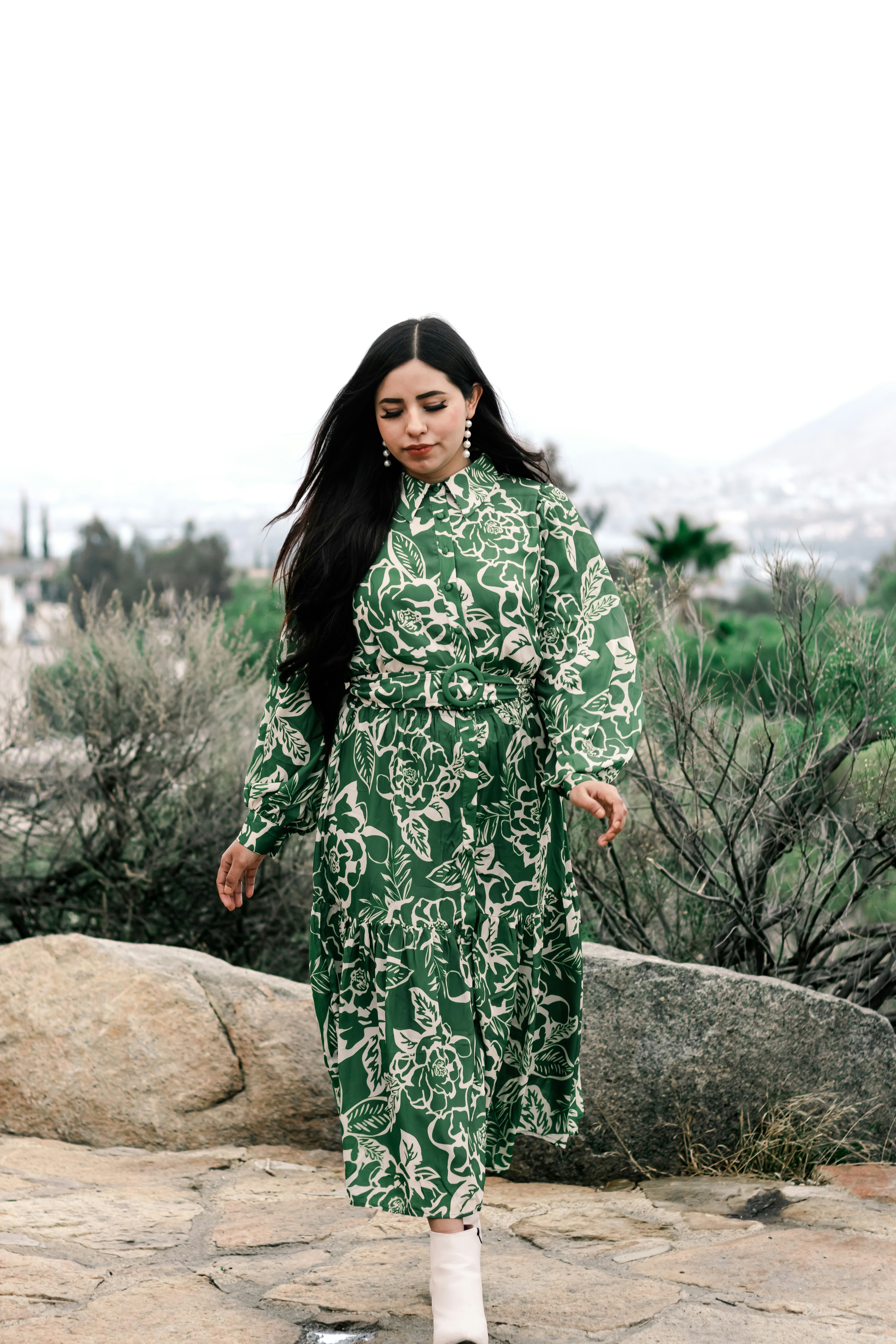 A woman in a green dress is standing on a rock photo – Free Tecate ...
