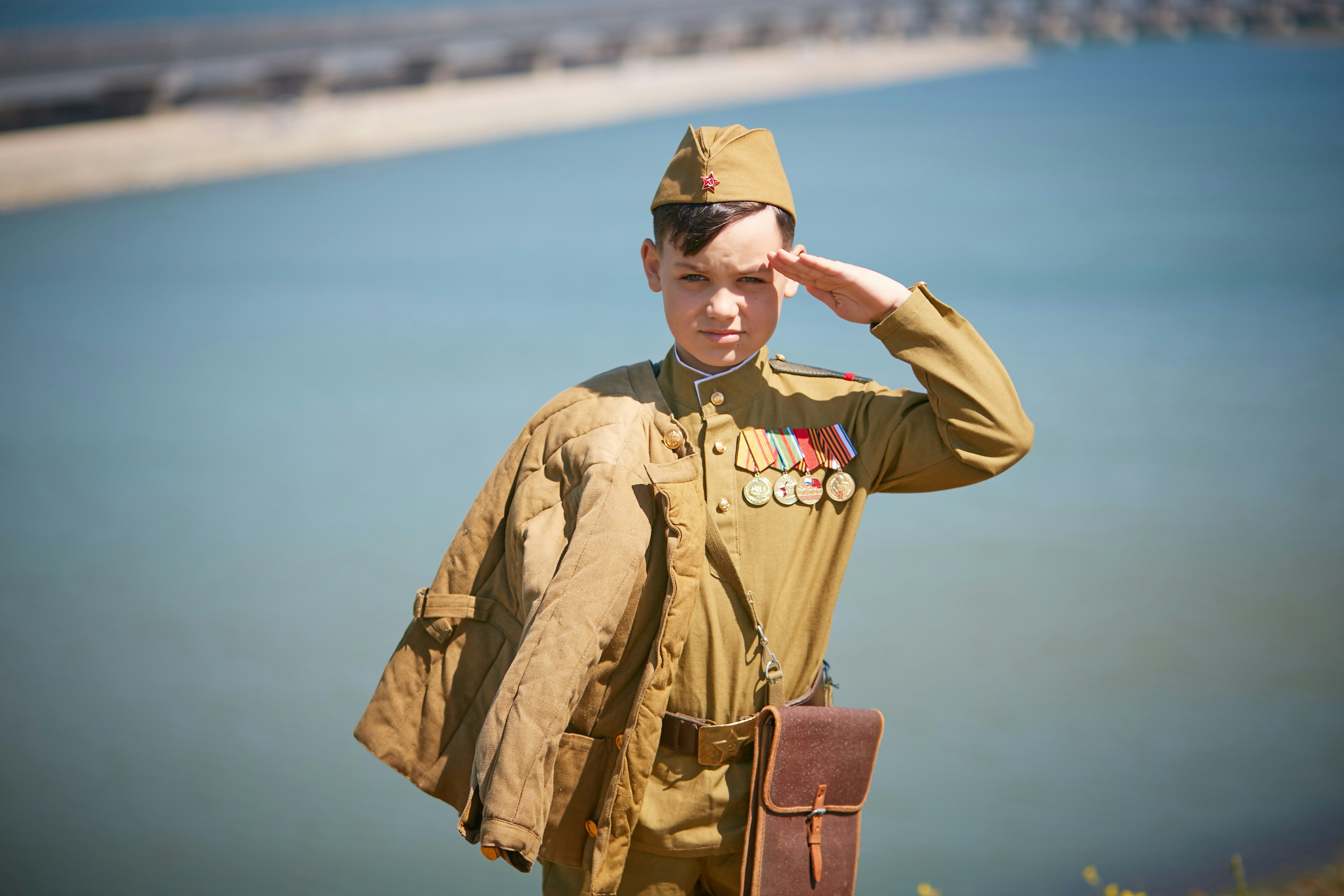 Coastal Cadet's Salute: medals gleam as a young officer stands by turquoise water