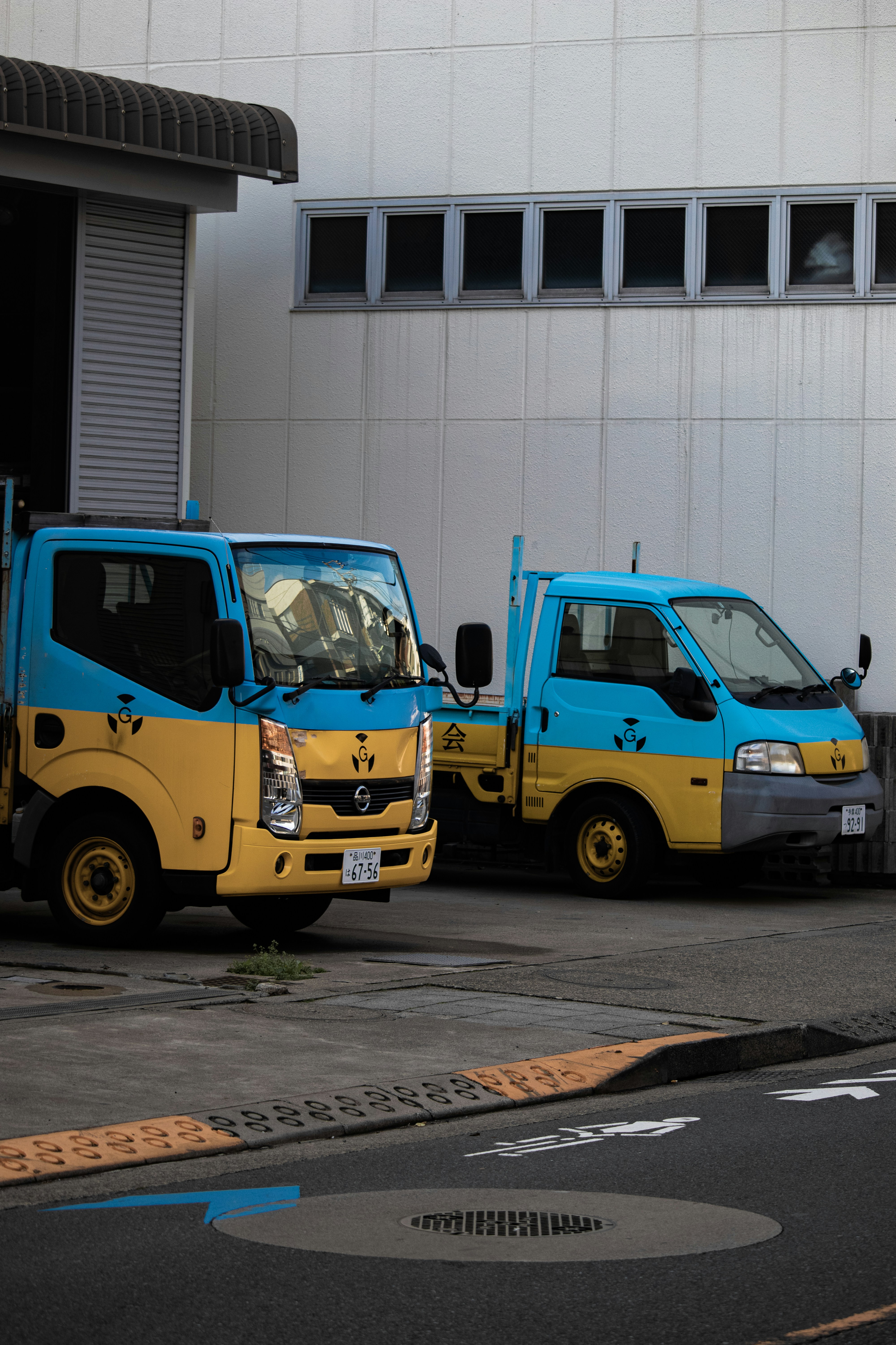Two-Tone Kei Trucks Guard a Quiet Loading Bay