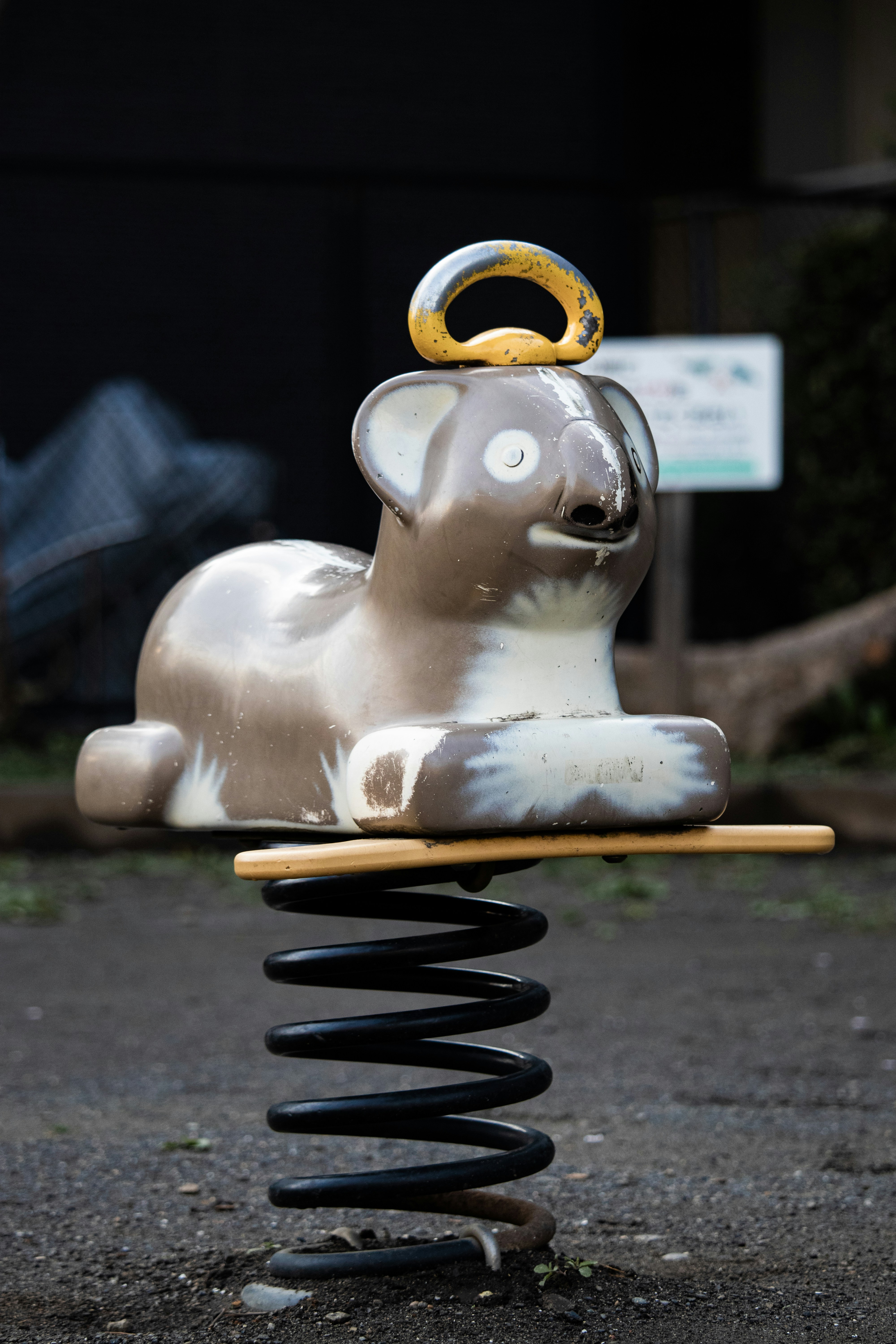 Weathered Goat Rider on a Coiled Spring: A Quiet Playground Portrait