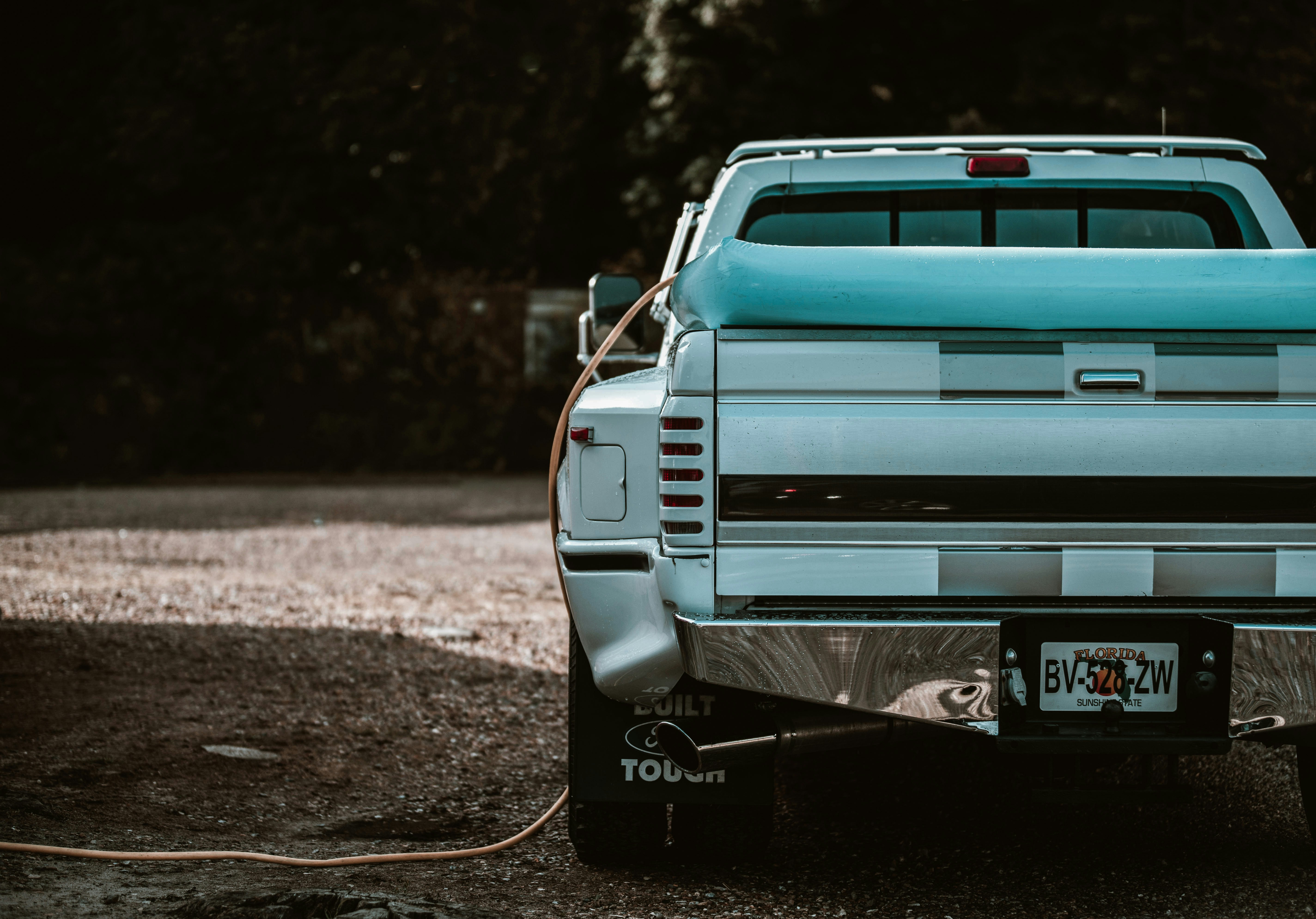 Teal Vintage Pickup on a Dusty Lot with an Orange Extension Cord