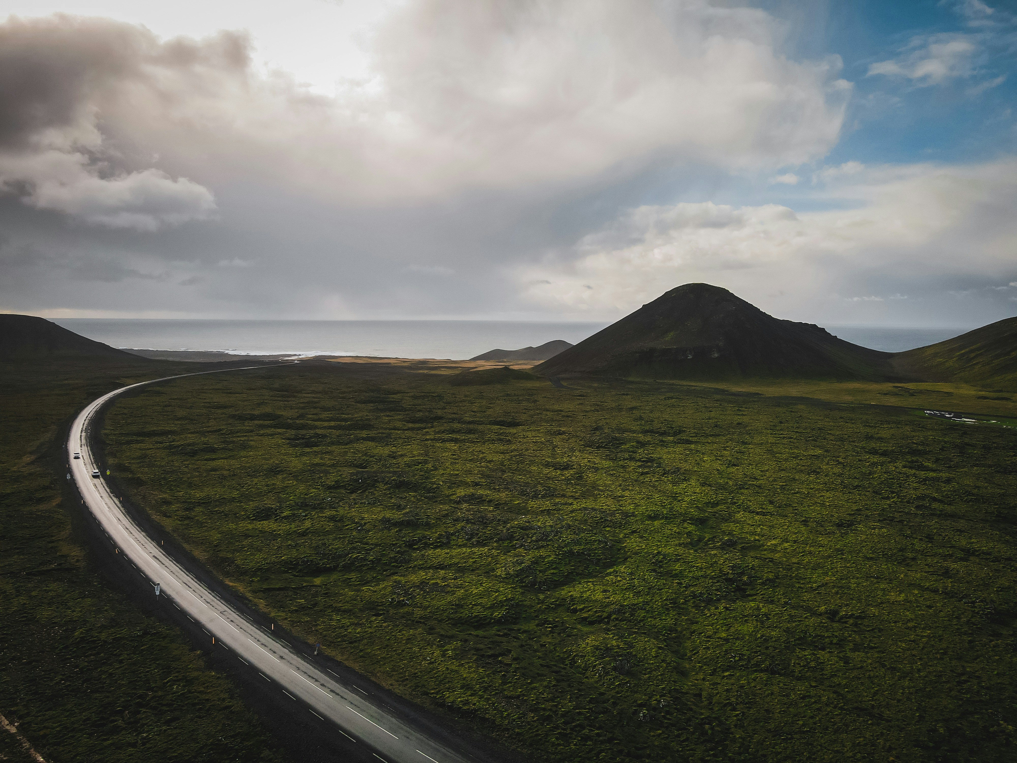 Curved Highway Through a Mossy Moor Under Expansive Sky