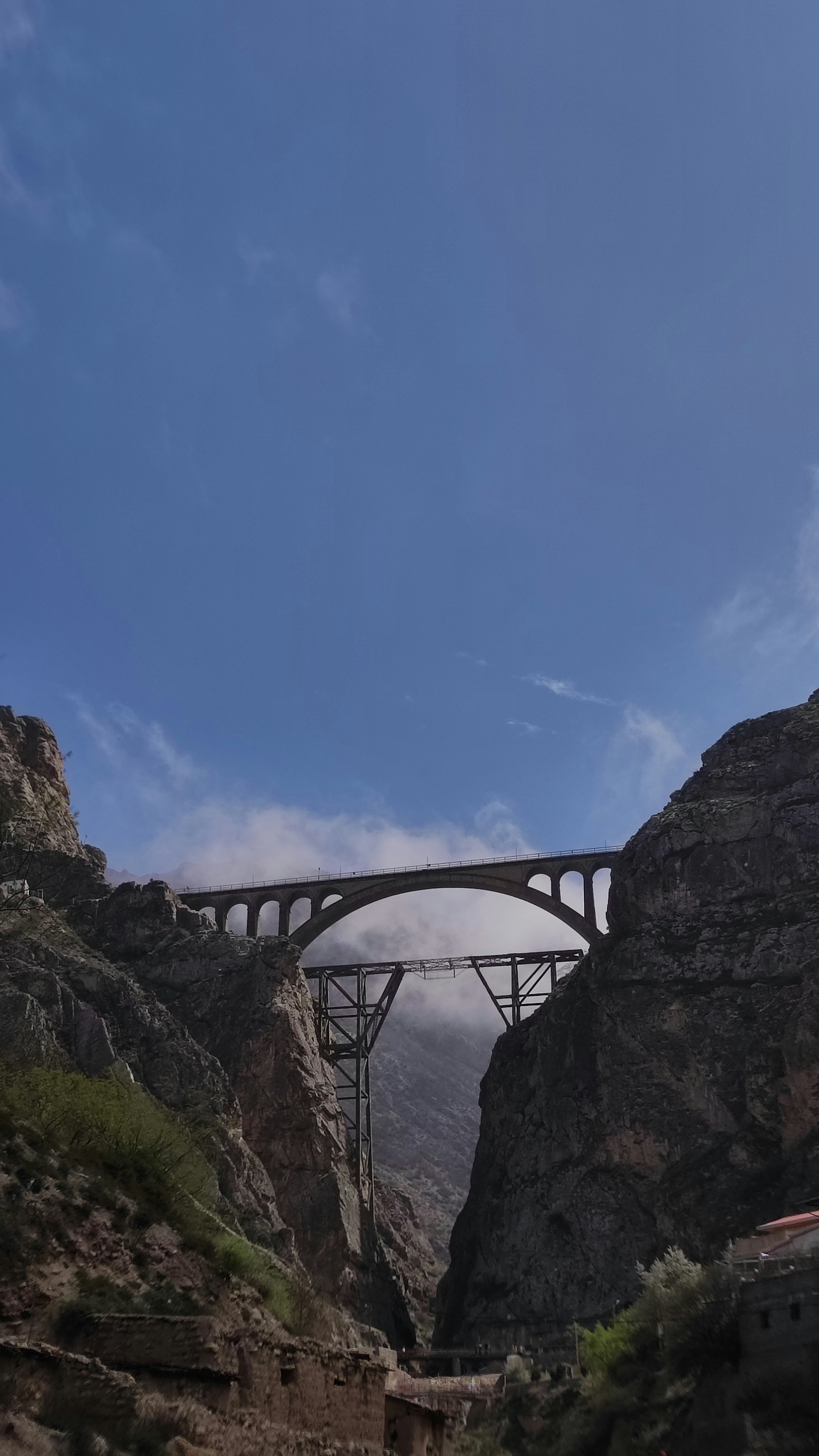 A bridge over a canyon with a mountain in the background photo – Free ...