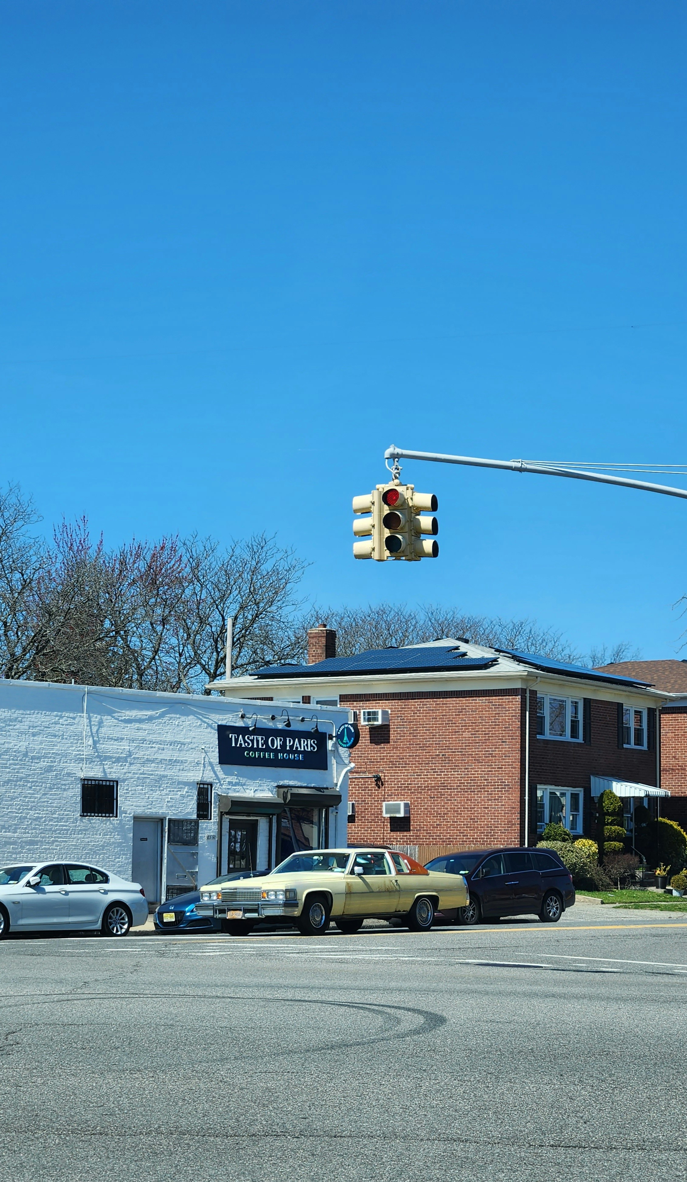 A traffic light hanging over a street next to a building photo – Free ...