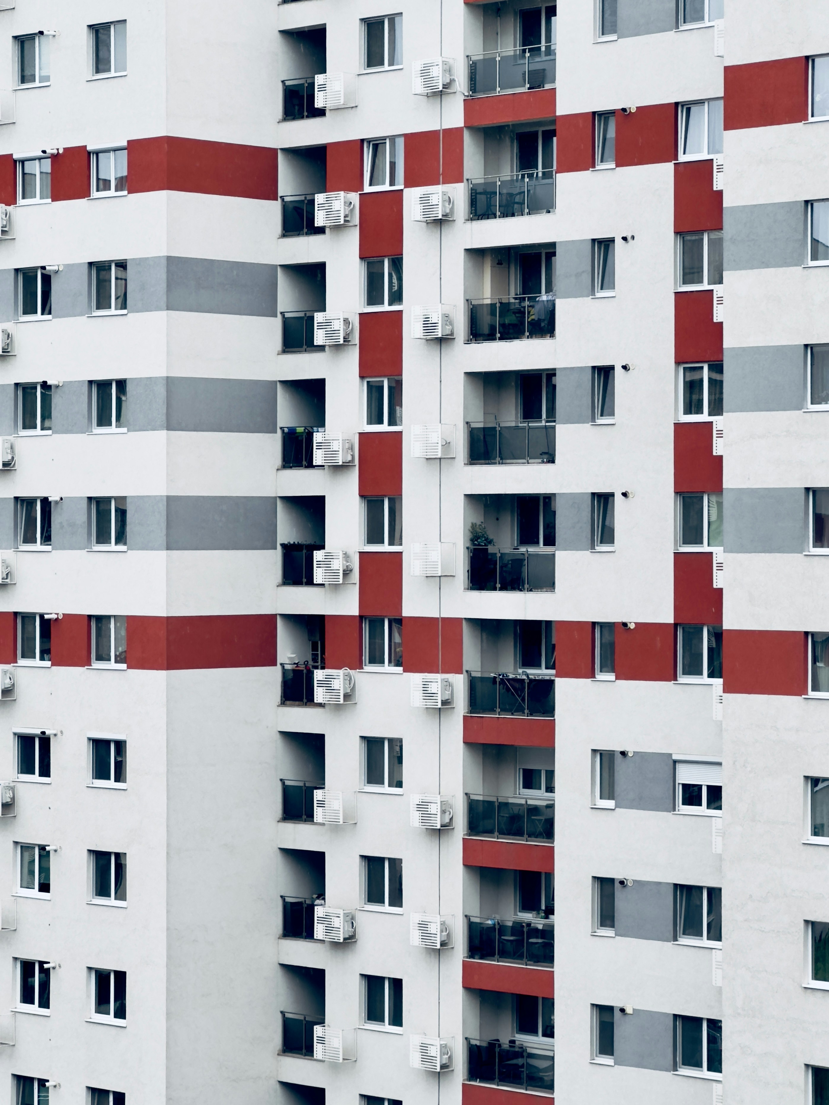 A tall white and red building with many windows photo – Free Building ...