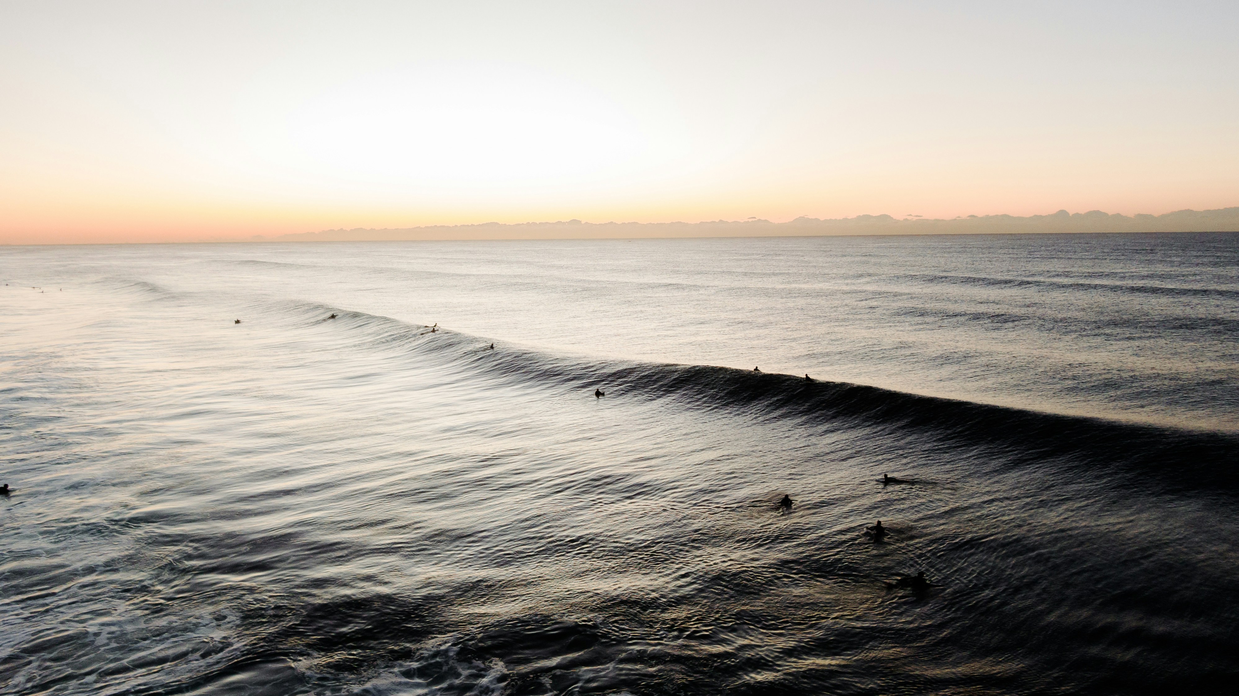 A group of people riding waves on top of surfboards photo – Free Nature ...