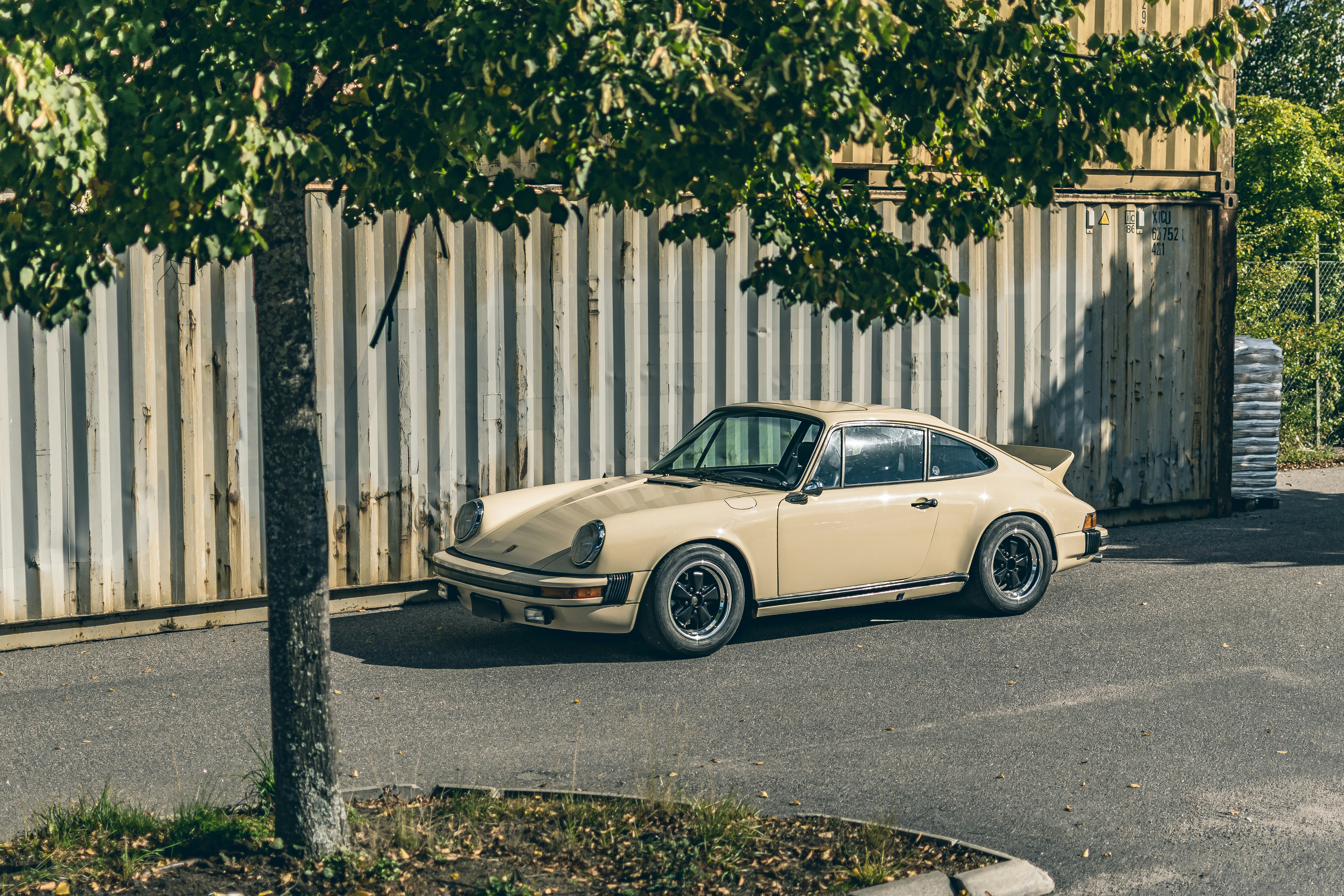 A tan porsche parked in front of a metal fence photo – Free Tire Image ...