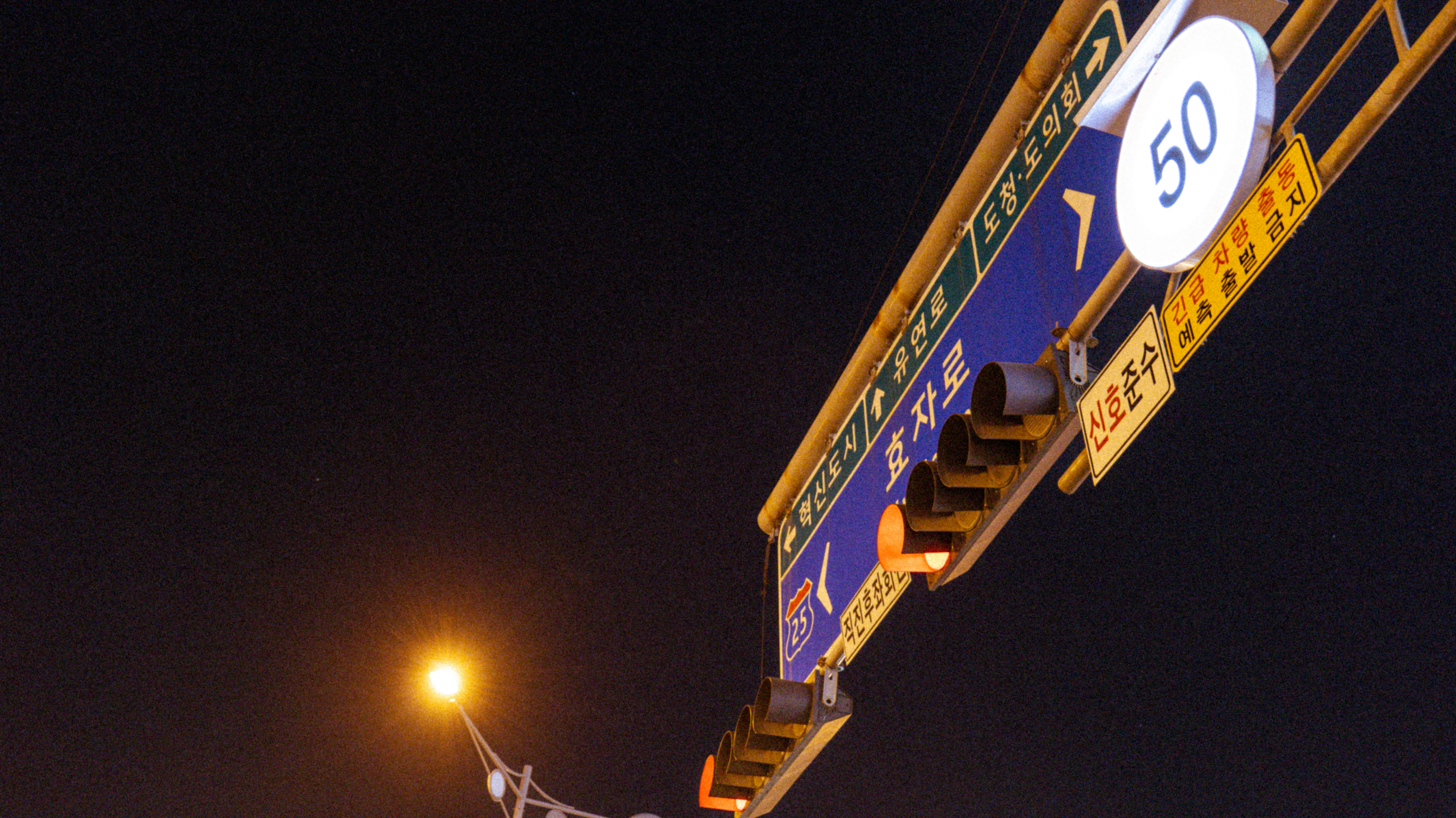 Blue 50 at Night: A Signpost Under Amber Glow