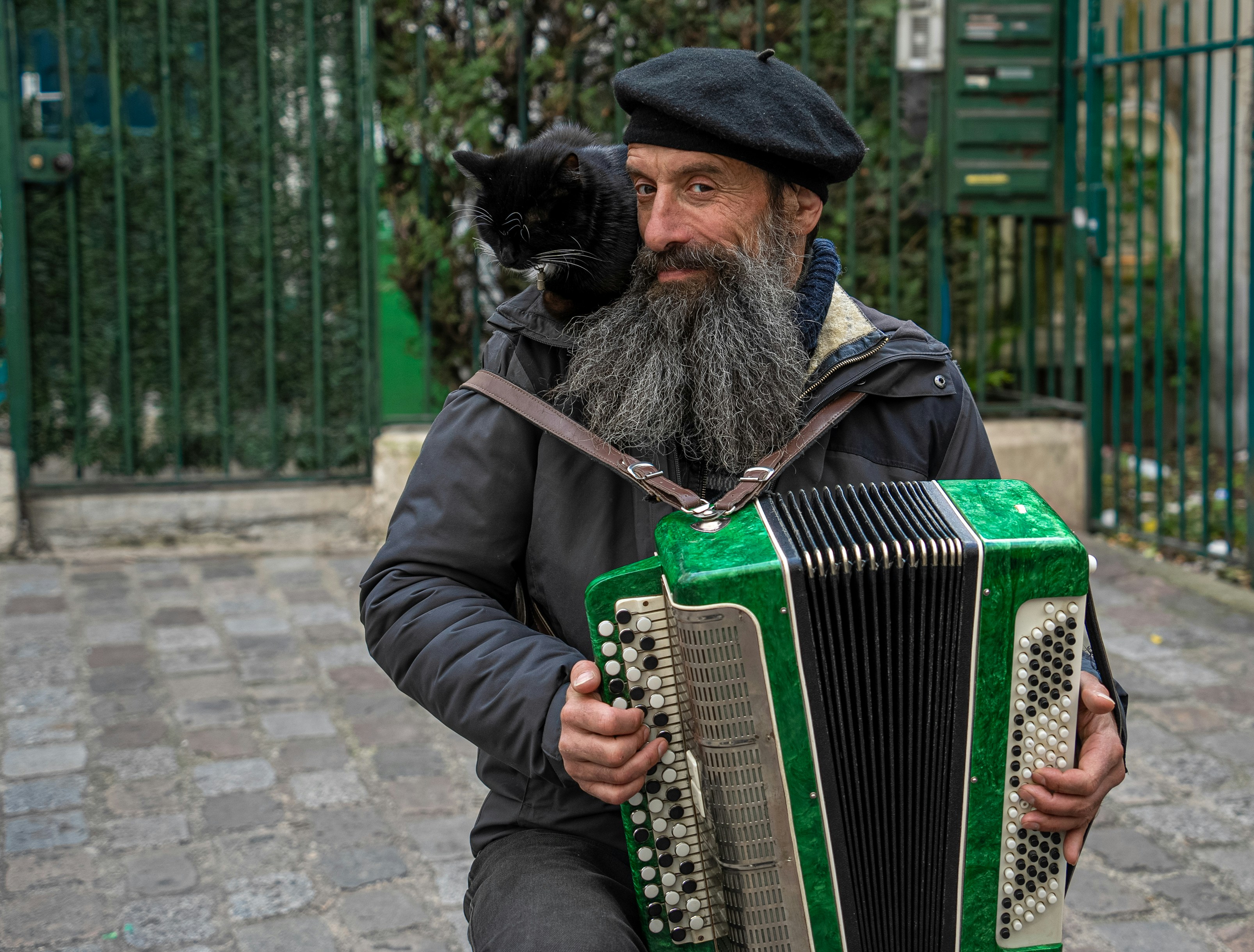 a man with a long beard holding a green accordion