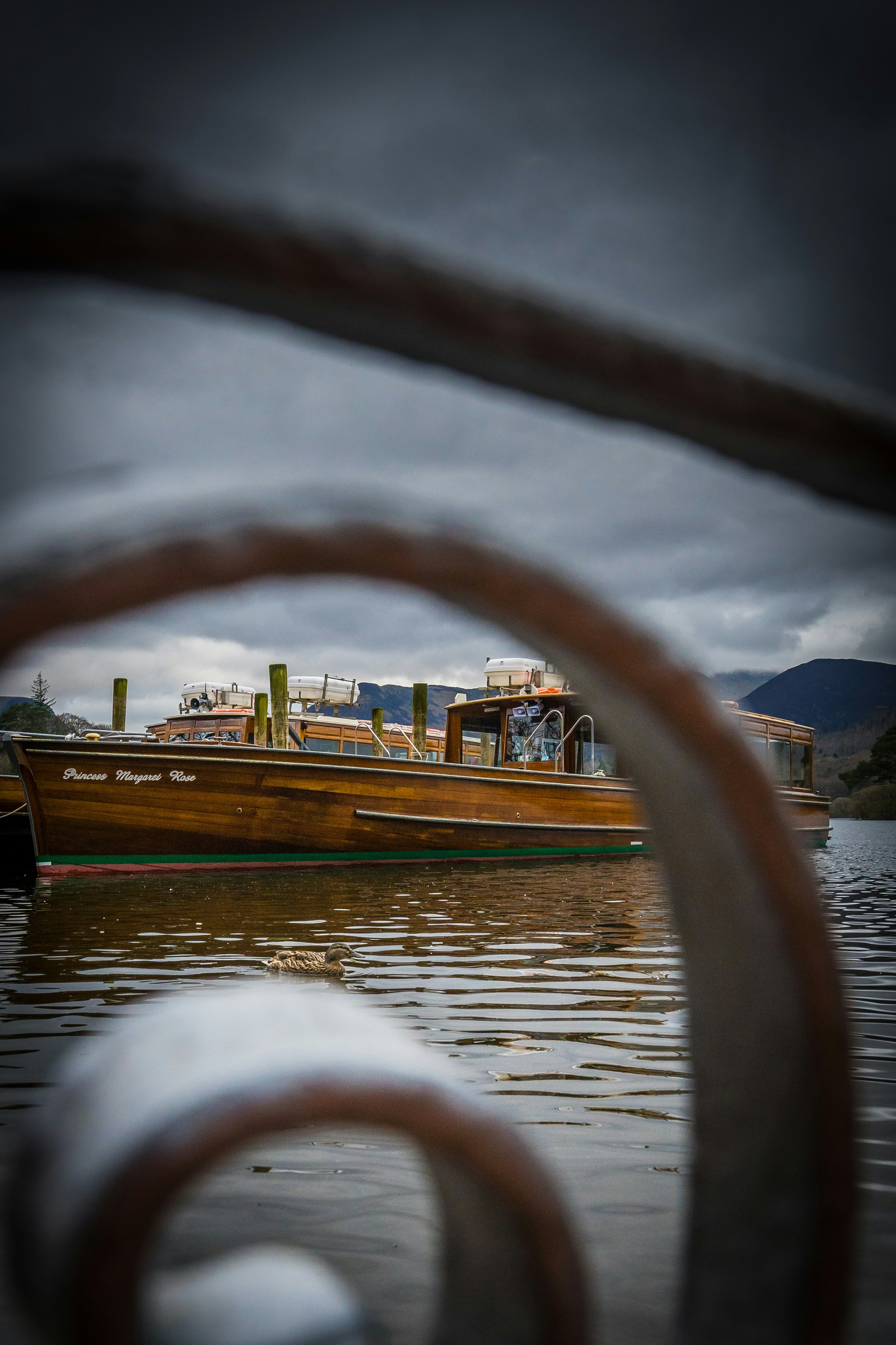 Through the Ring: A Vintage Boat Resting on a Quiet Lake Framed by Weathered Circles