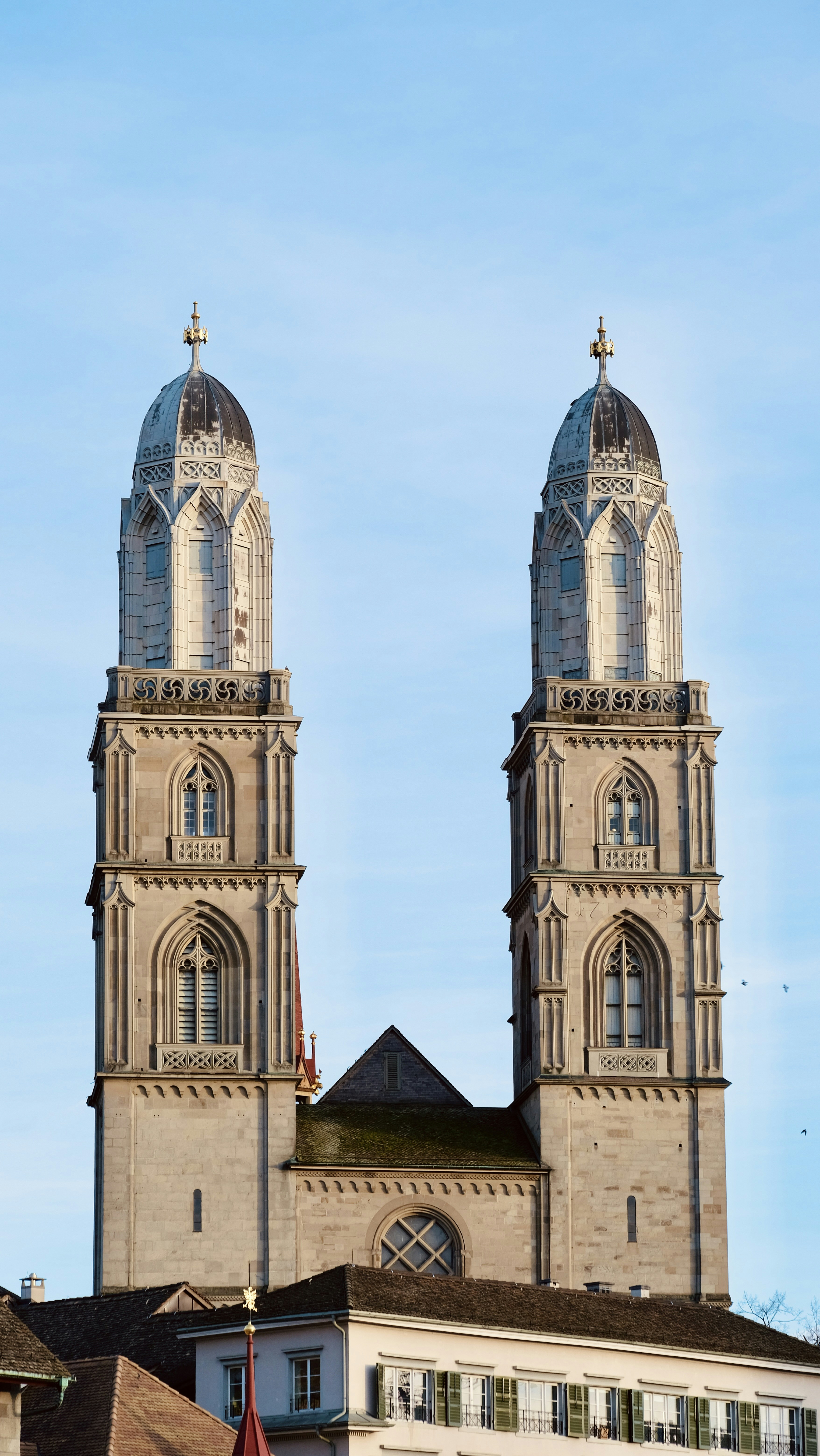 Symmetry in Stone: Twin Gothic Towers Against a Clear Blue Sky