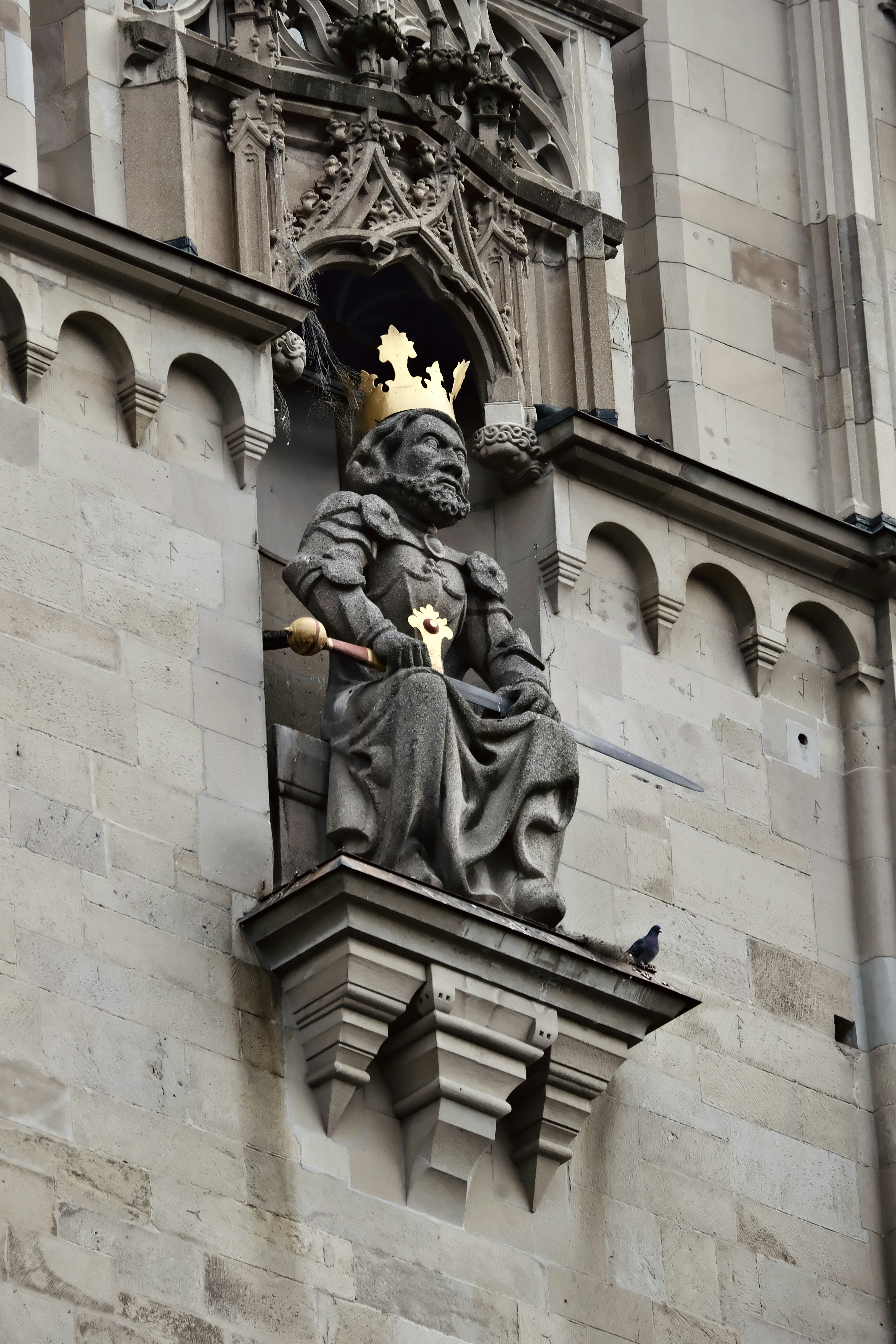 Crowned Guardian on Stone: A Gothic King Overlooking the Cathedral Facade