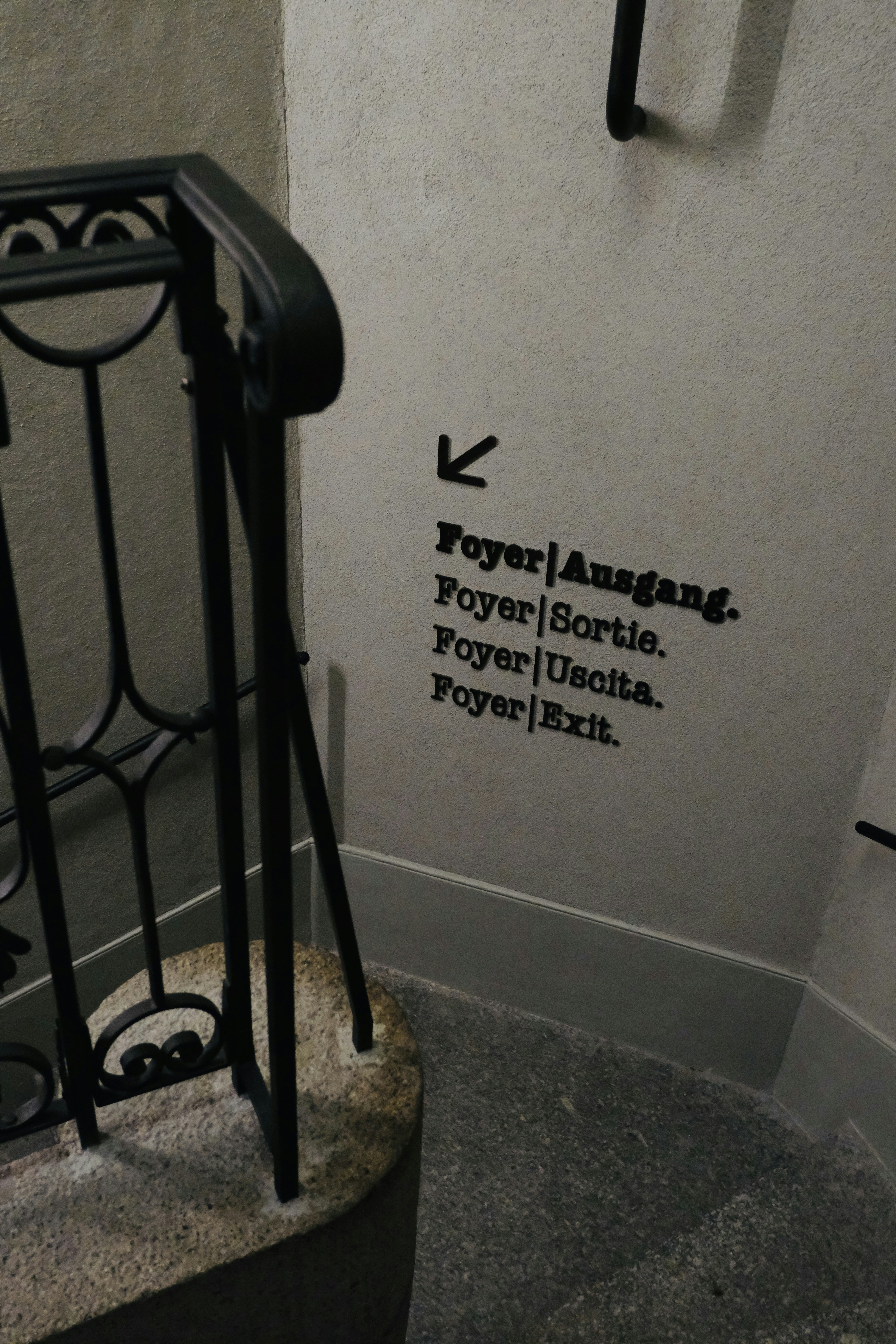 Whispered Exits: Stencil Text Guides the Concrete Stairwell