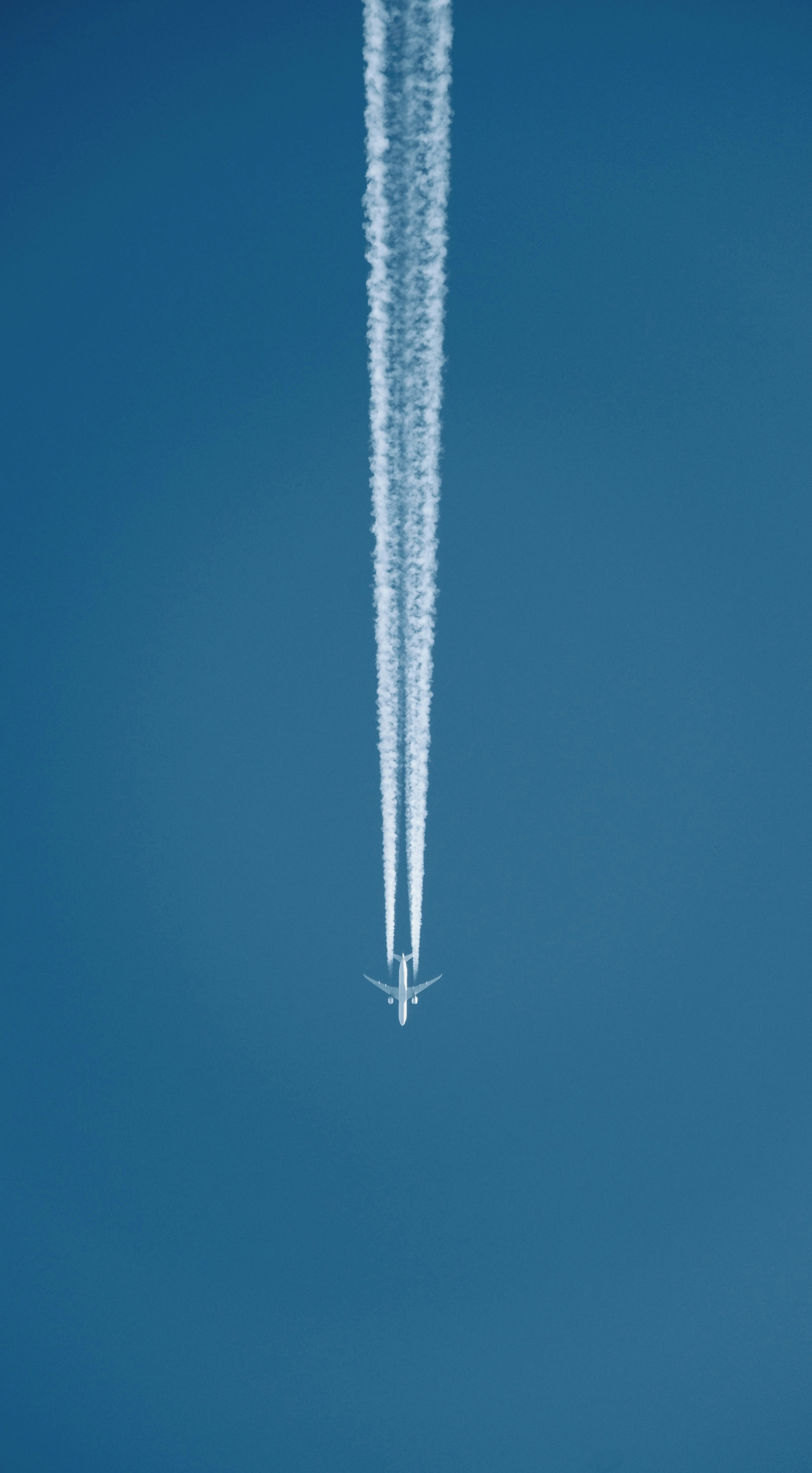 A jet flying through a blue sky leaving a trail of smoke photo – Free ...