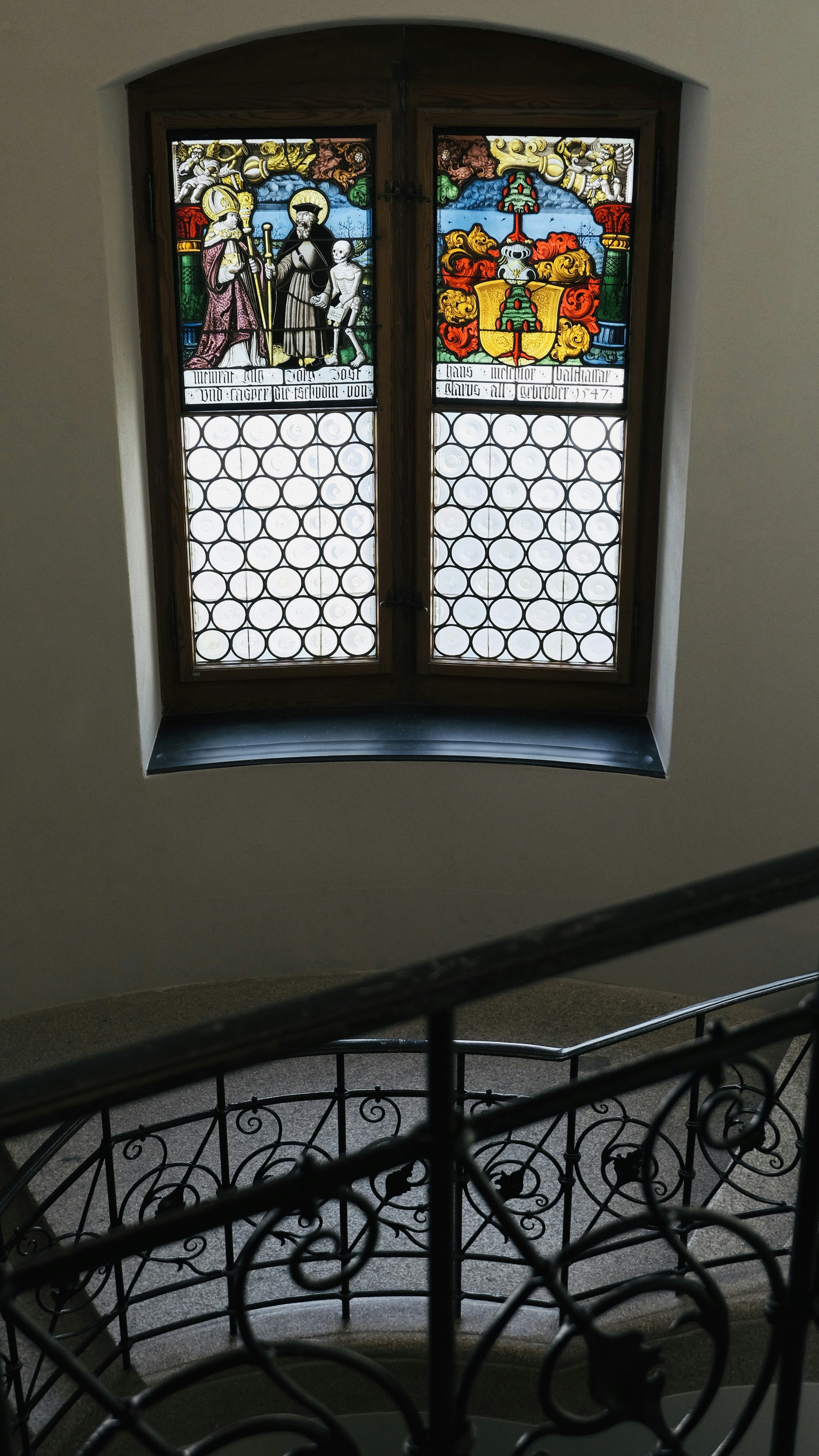 a stained glass window in the corner of a stairwell