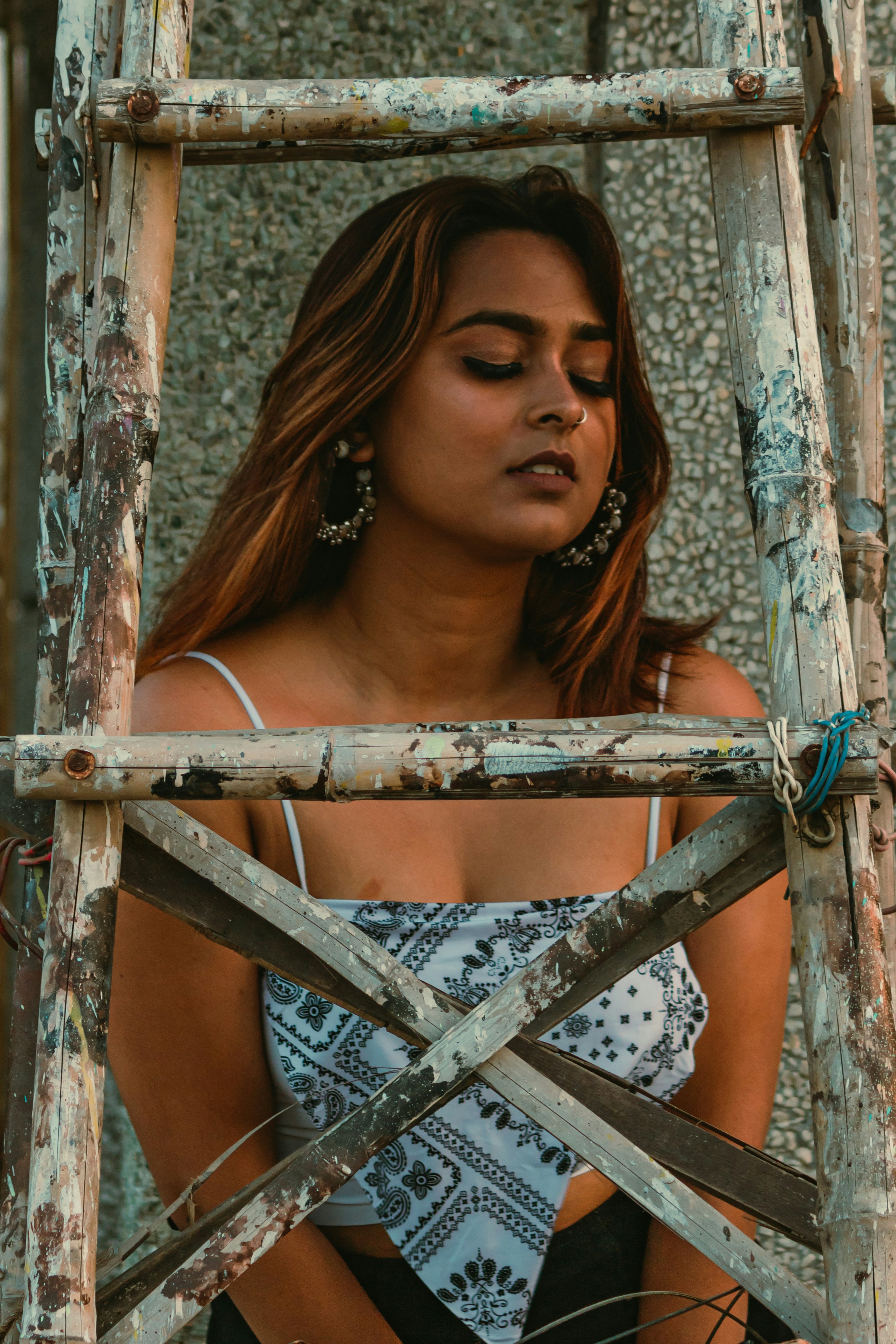 A woman sitting on a ladder with her eyes closed photo – Free Woman ...