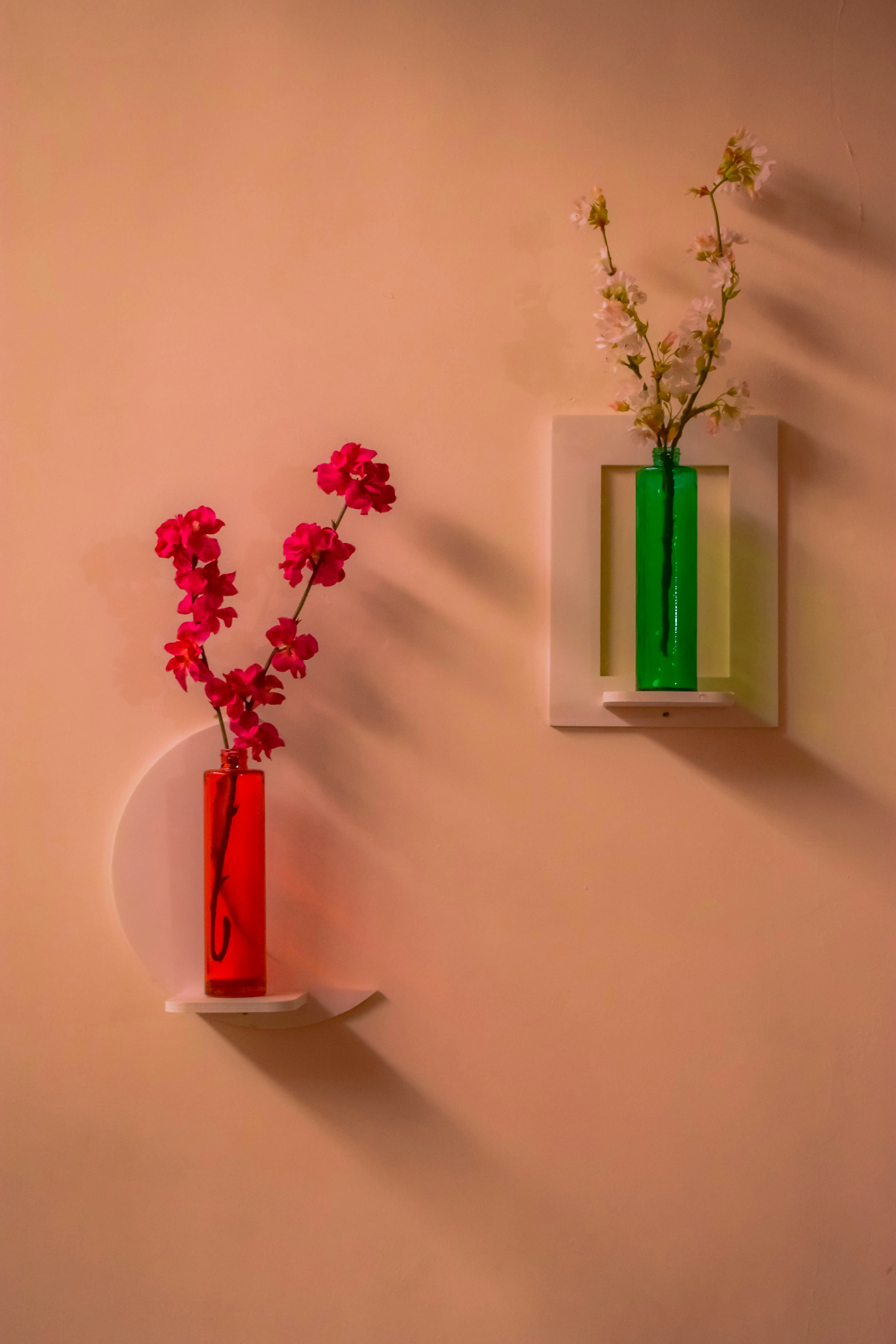 Muted Bloom Duo: Red and Green Vases on a Peach Wall