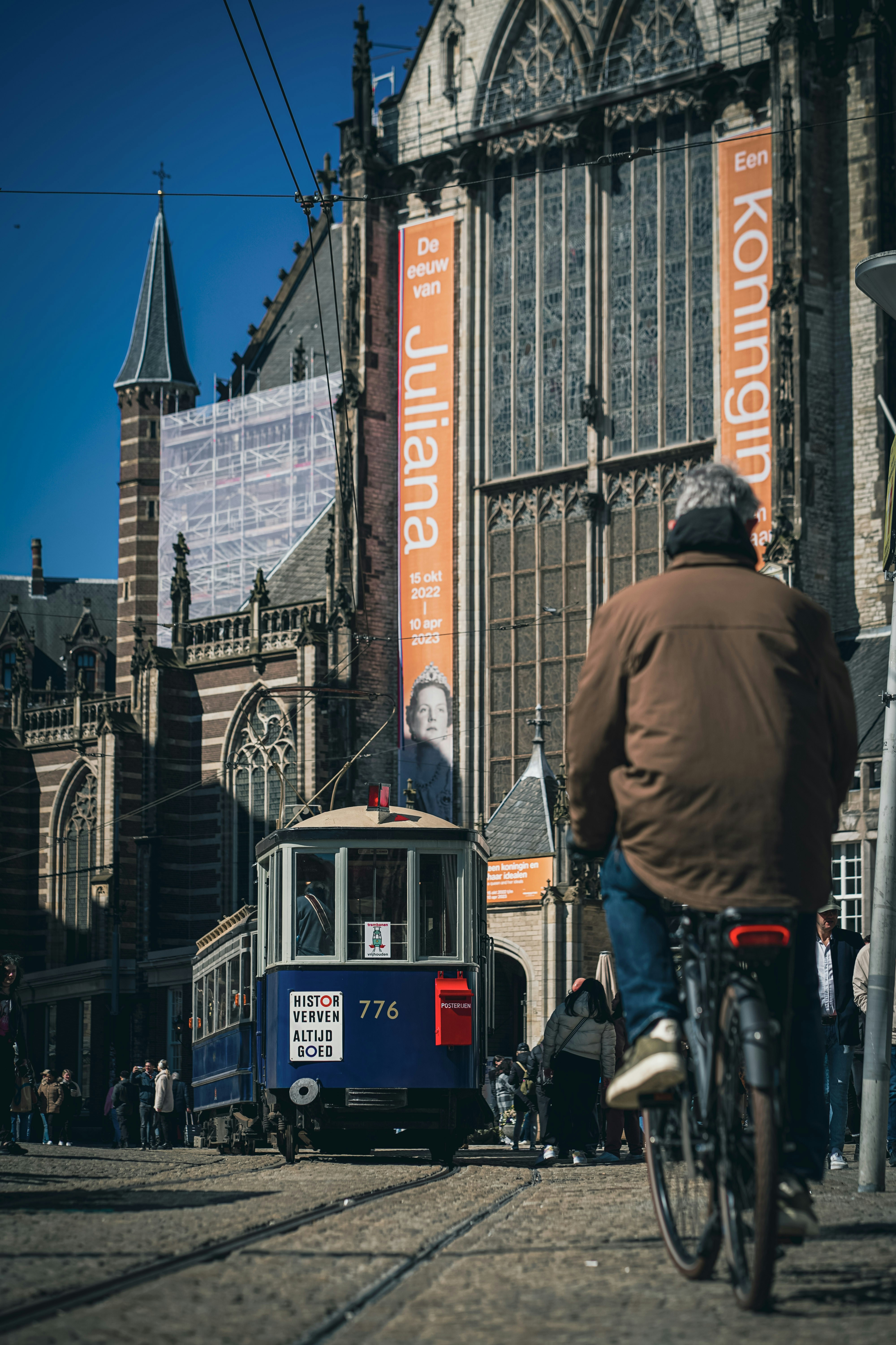 a man riding a bike down a street next to a trolley